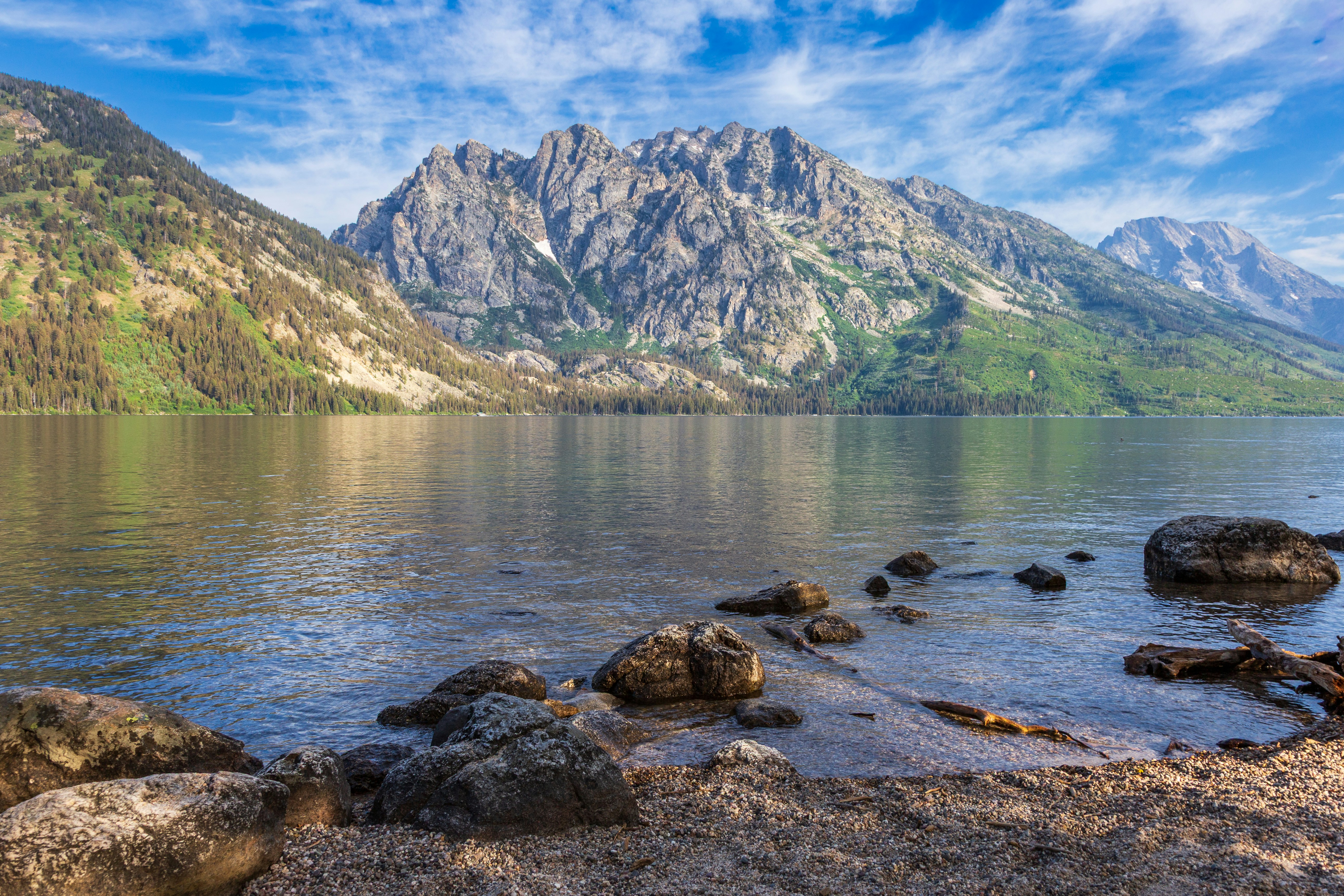 Lakeside Sentinel: Mountain Range Reflects in Calm Alpine Waters