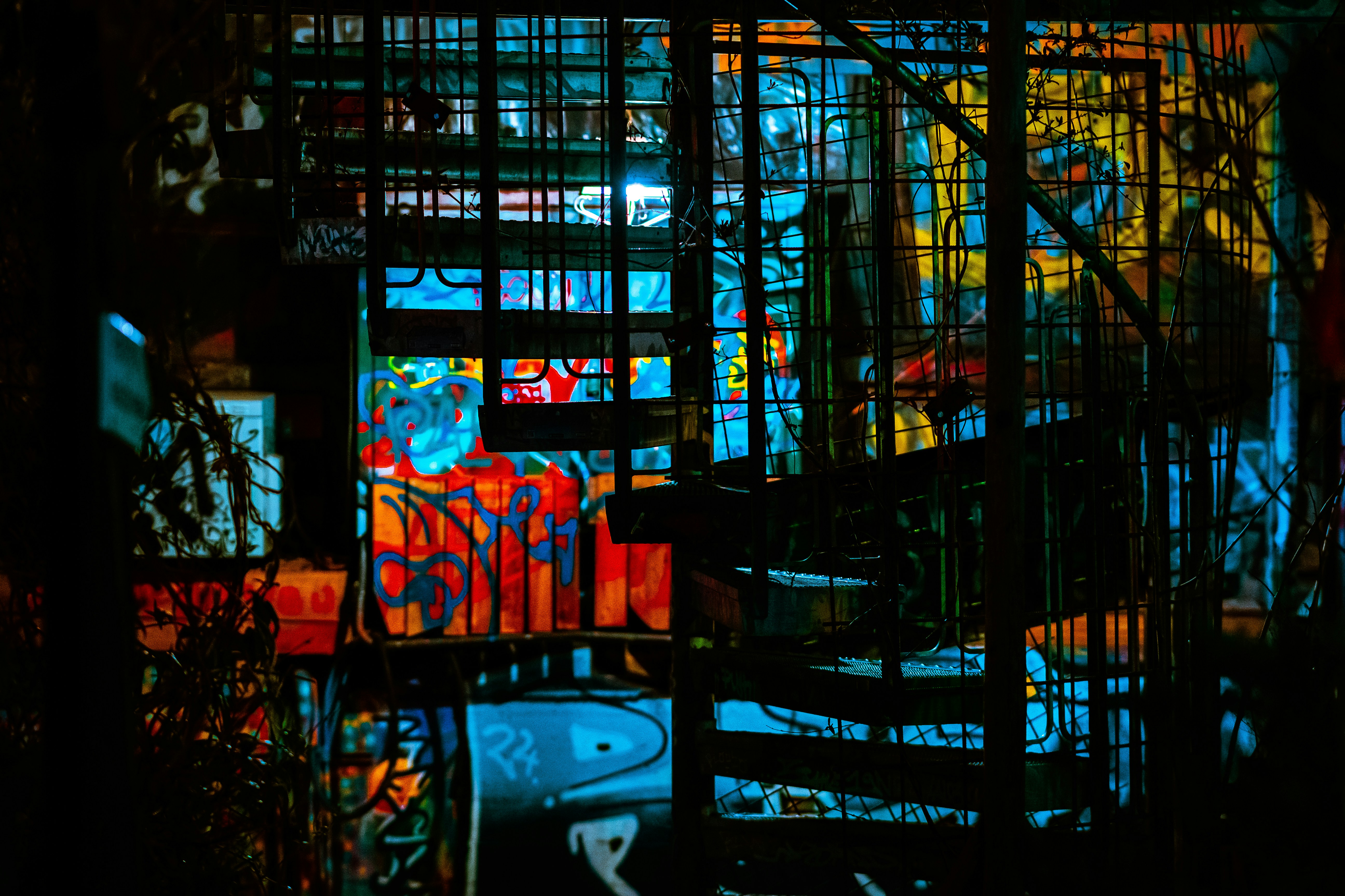 Hidden Staircase of Color: Graffiti Stairwell Through Metal Grid