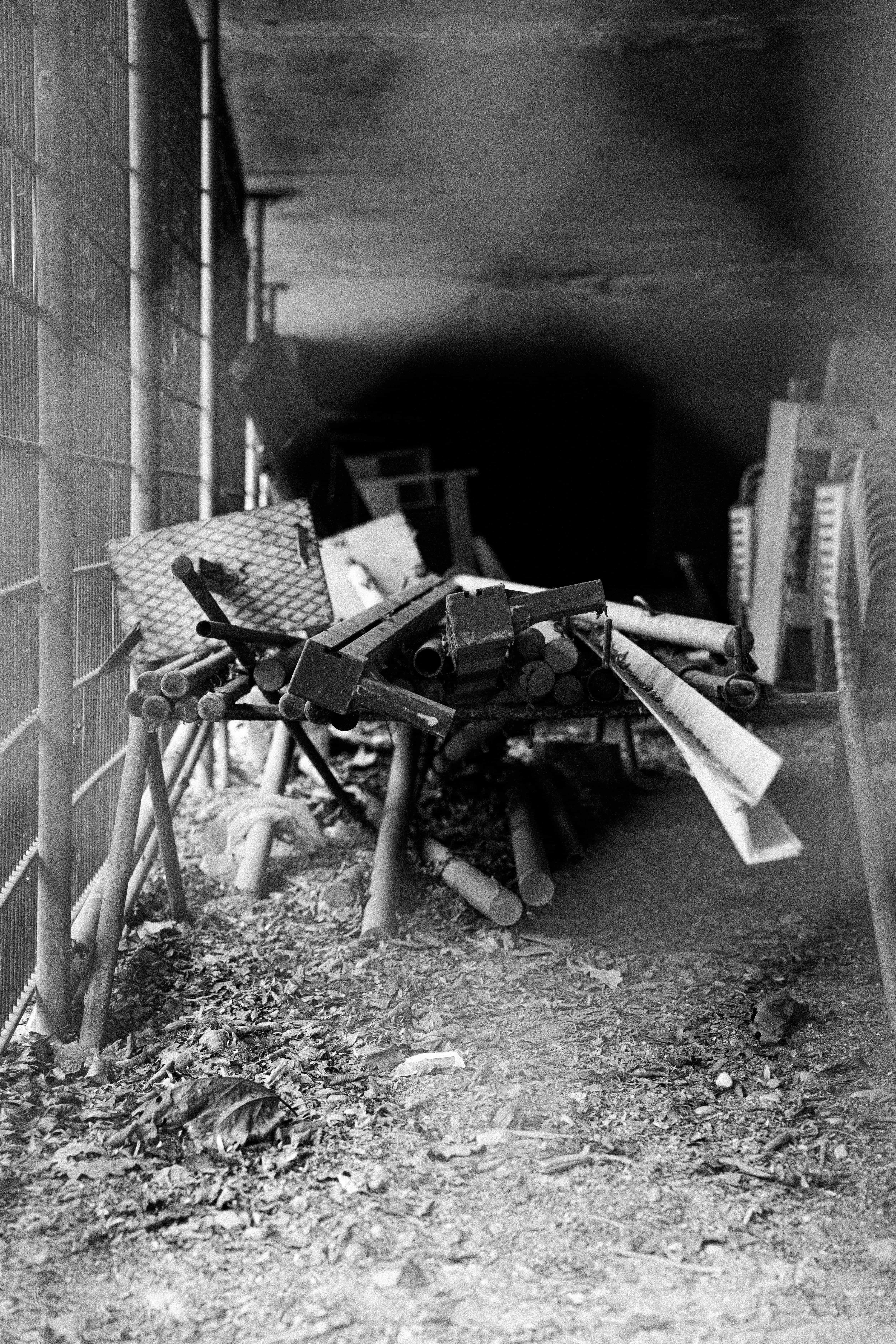 Shadowed Dump: Piled debris in a dim industrial corridor