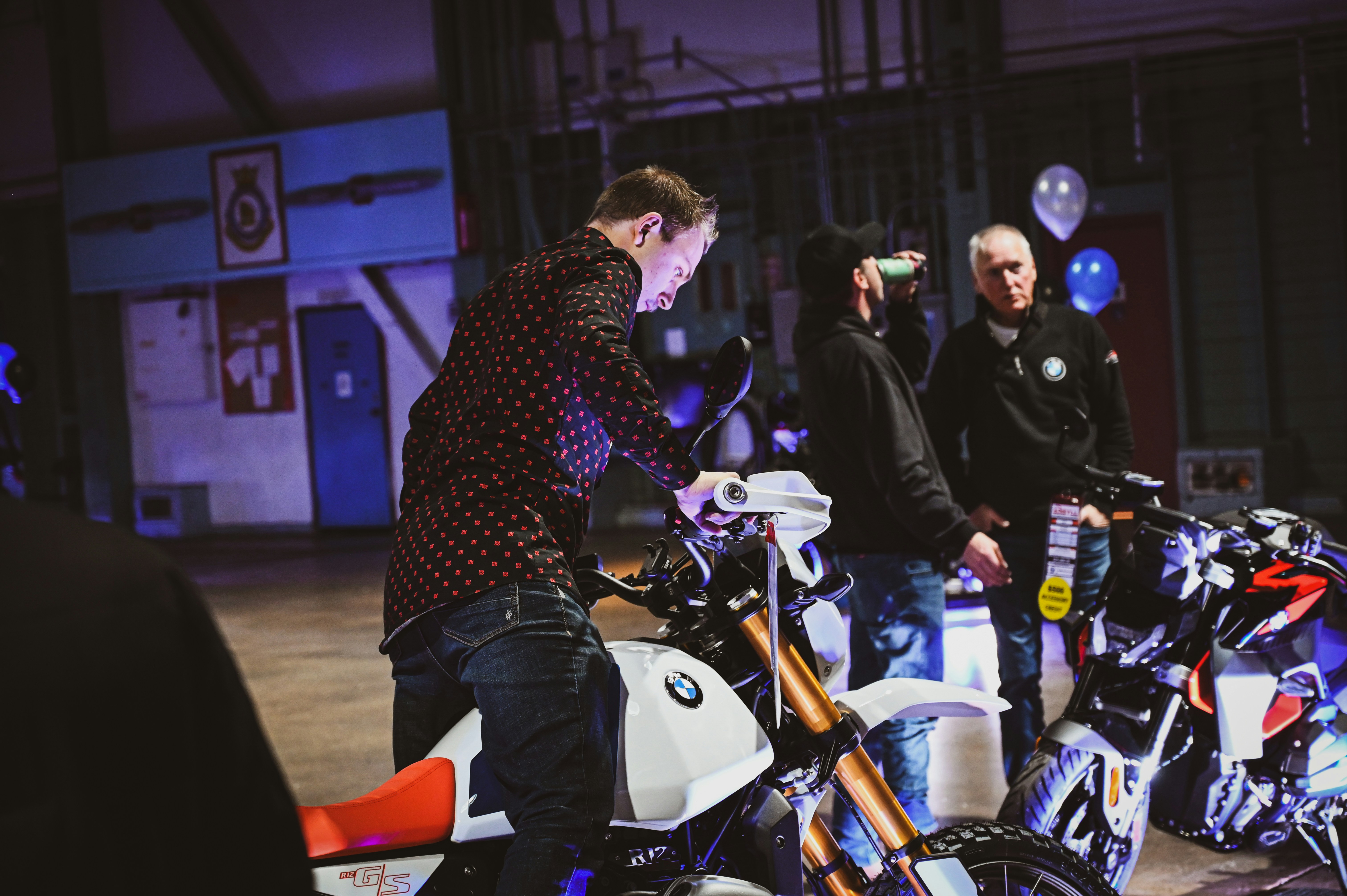 Midnight Run: A rider adjusts a BMW at a neon-lit bike show
