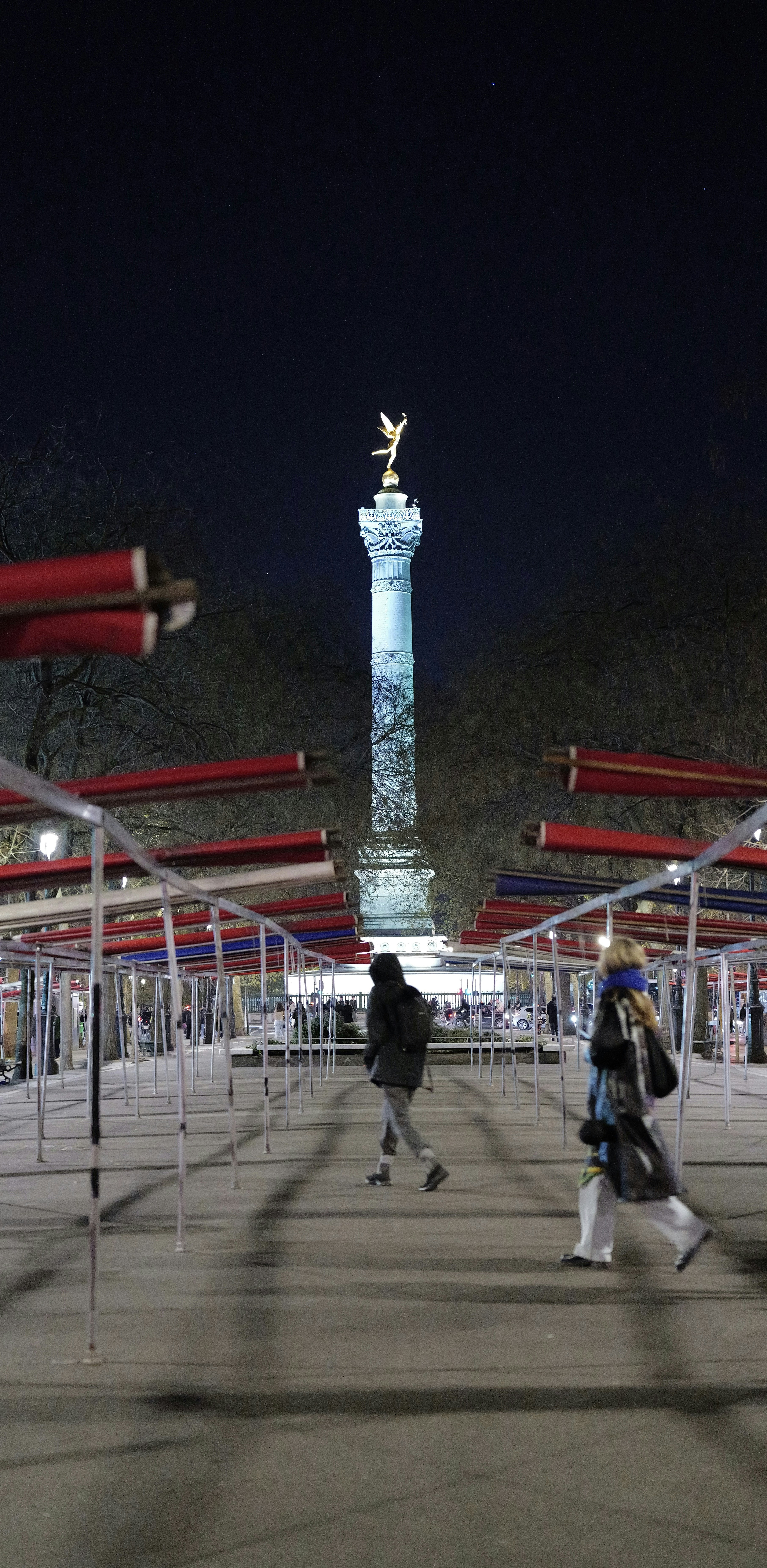 Column monument at night with empty market stalls