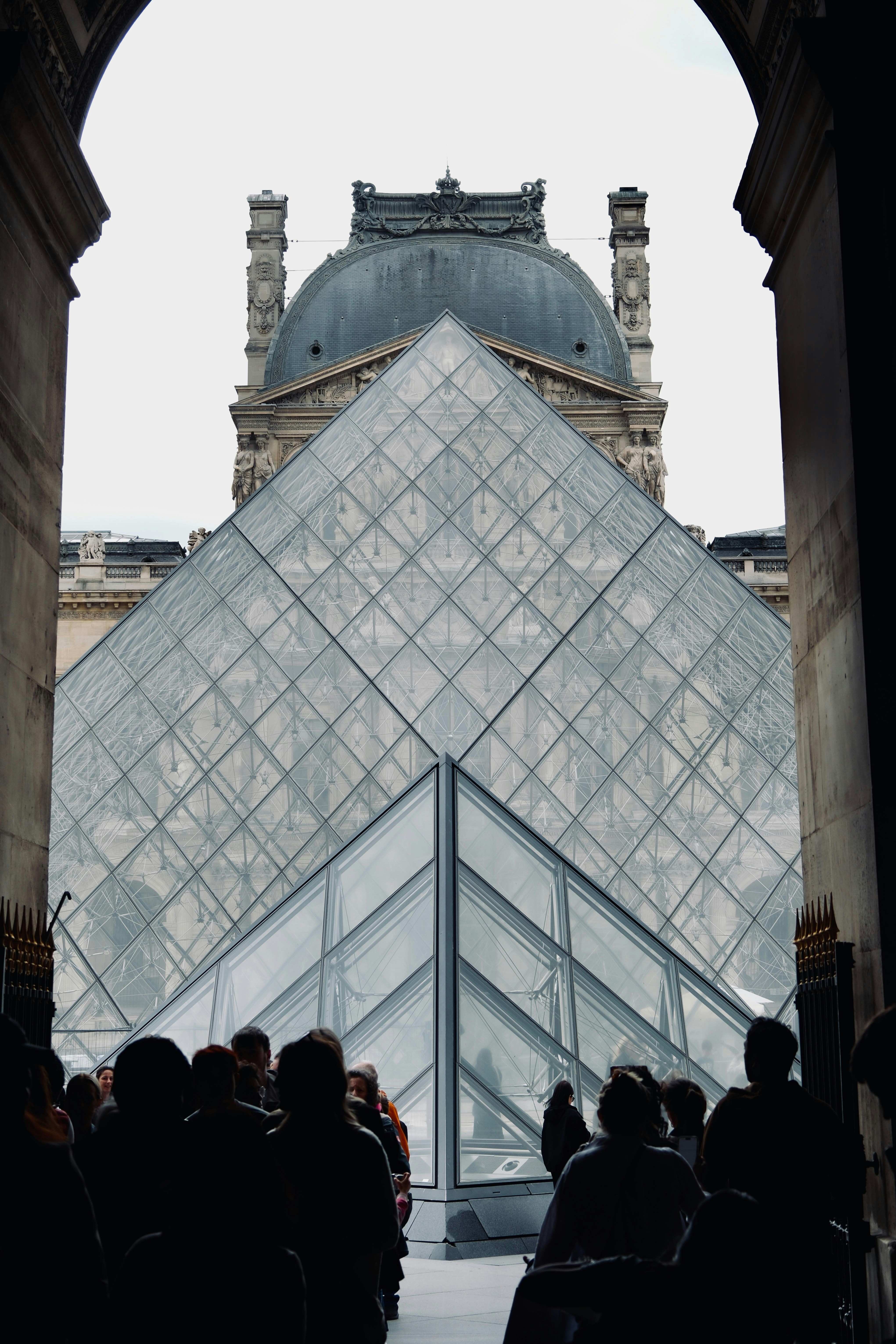 Glassed Monolith: The Louvre Pyramid Framed by Timeworn Facades