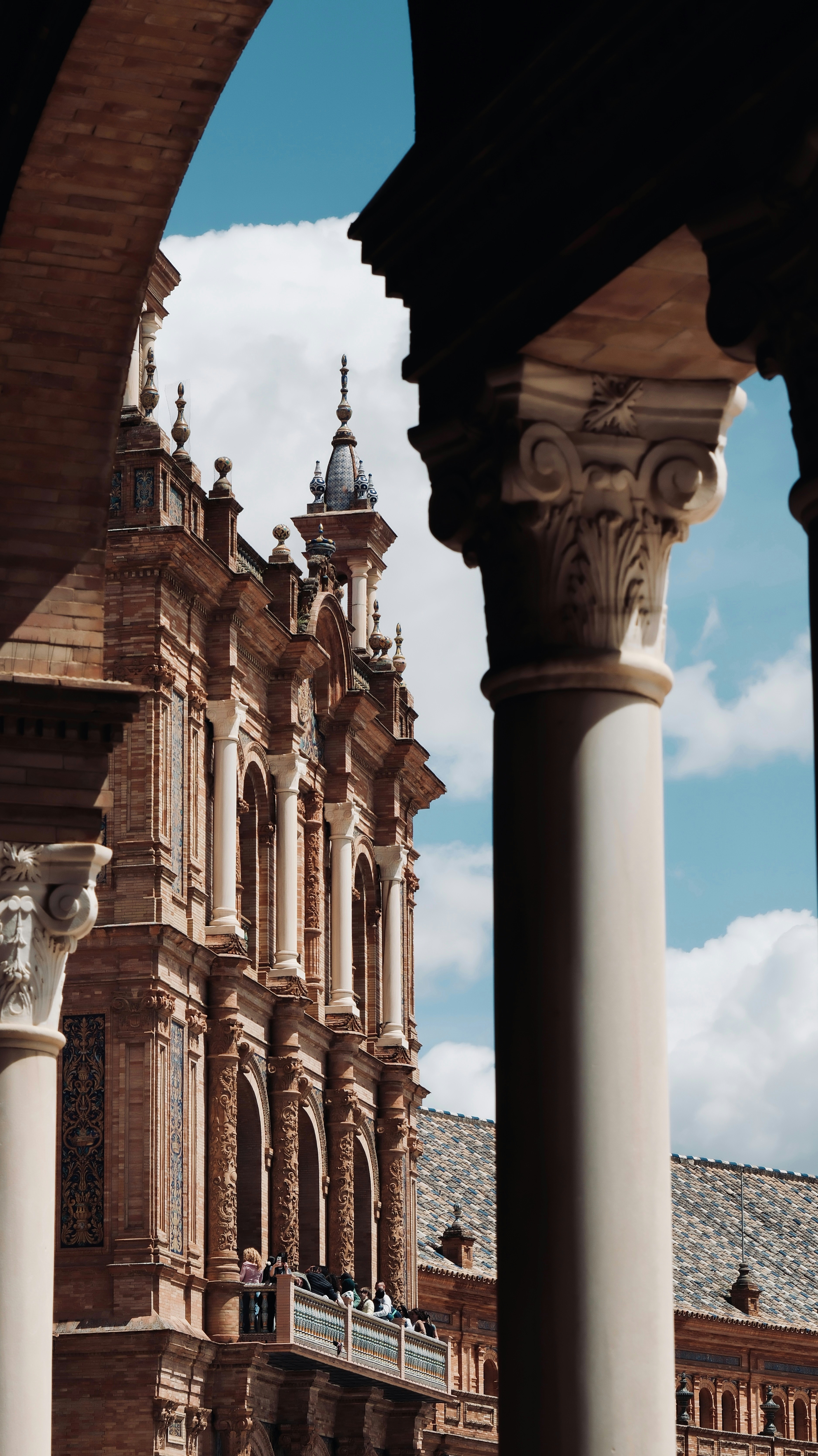  arches and columns of a Moorish-inspired palace framed by a foreground column