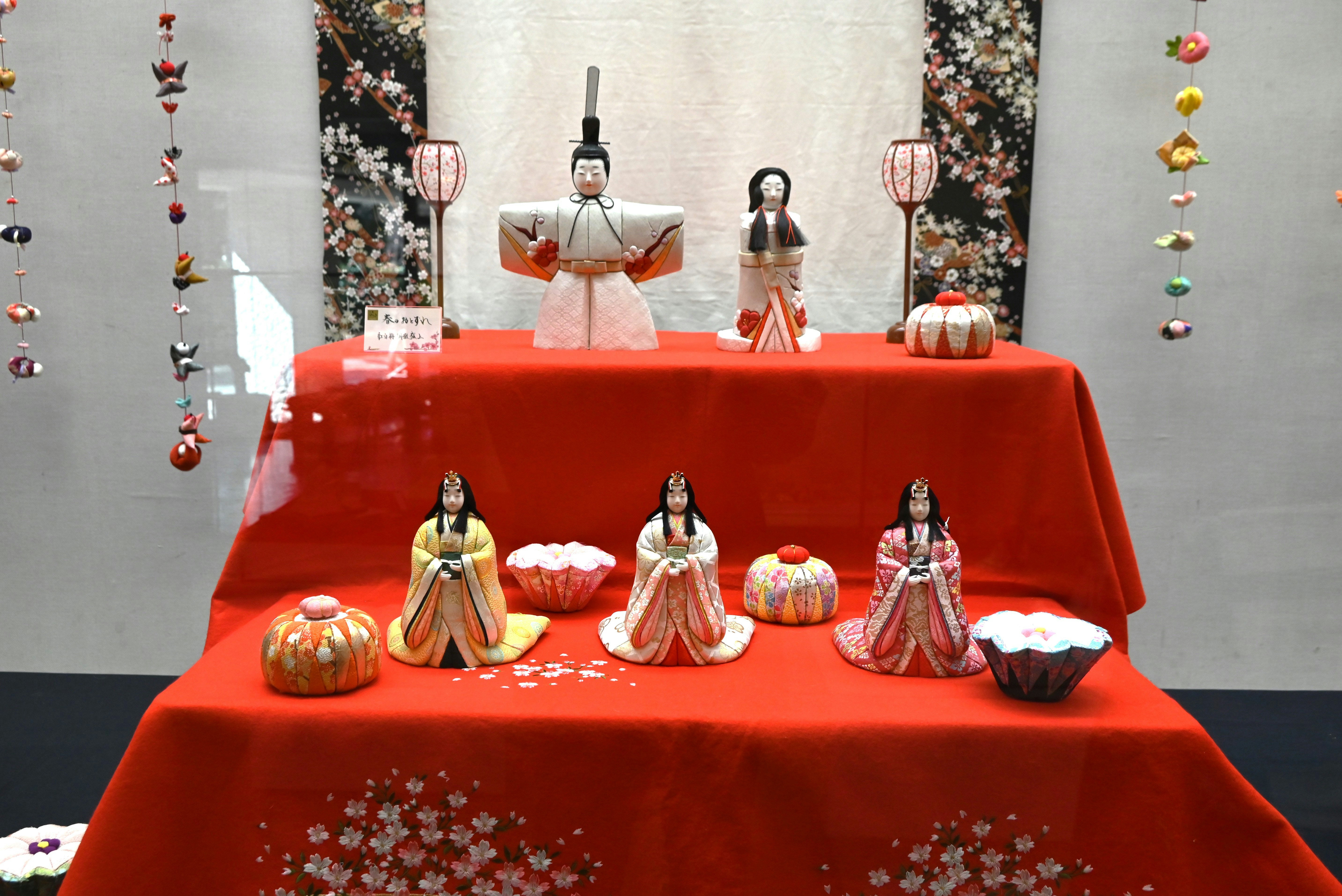 Tiered Hinadan Display: Traditional Dolls on a Red Spring Scene