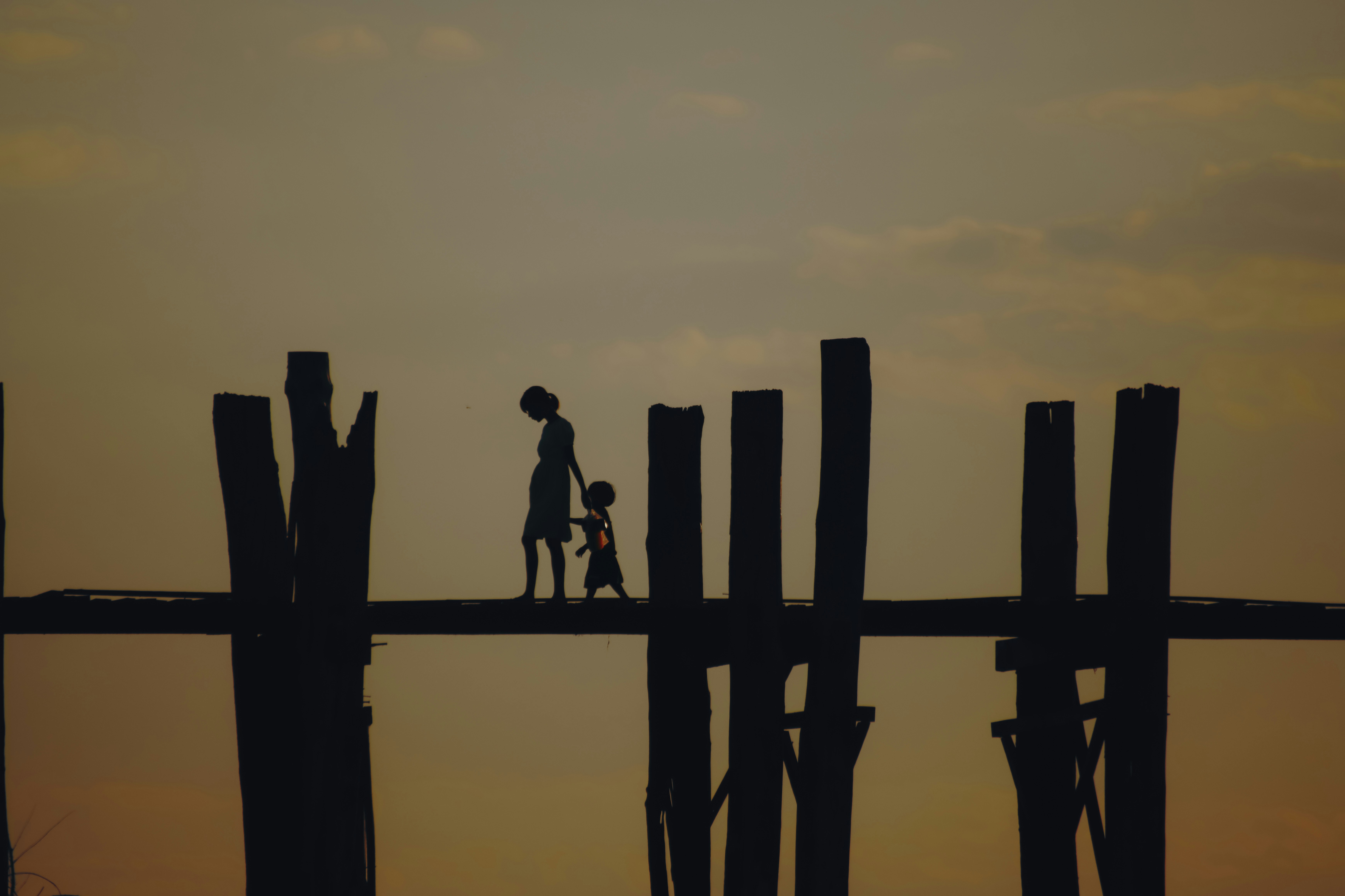 Silhouettes on a Weathered Pier at Sunset