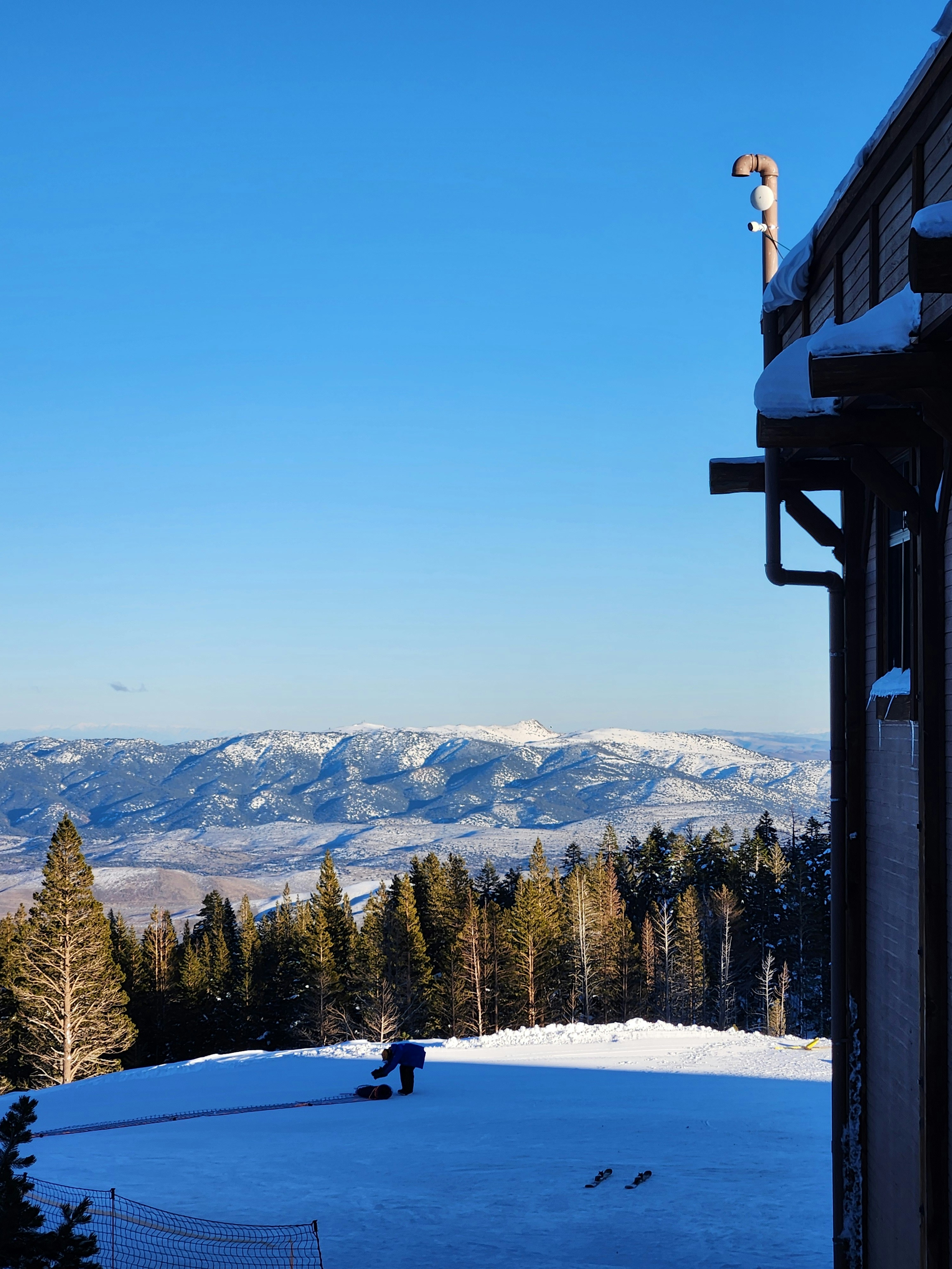 Snowfield with distant Range Framed by a Cabin Edge