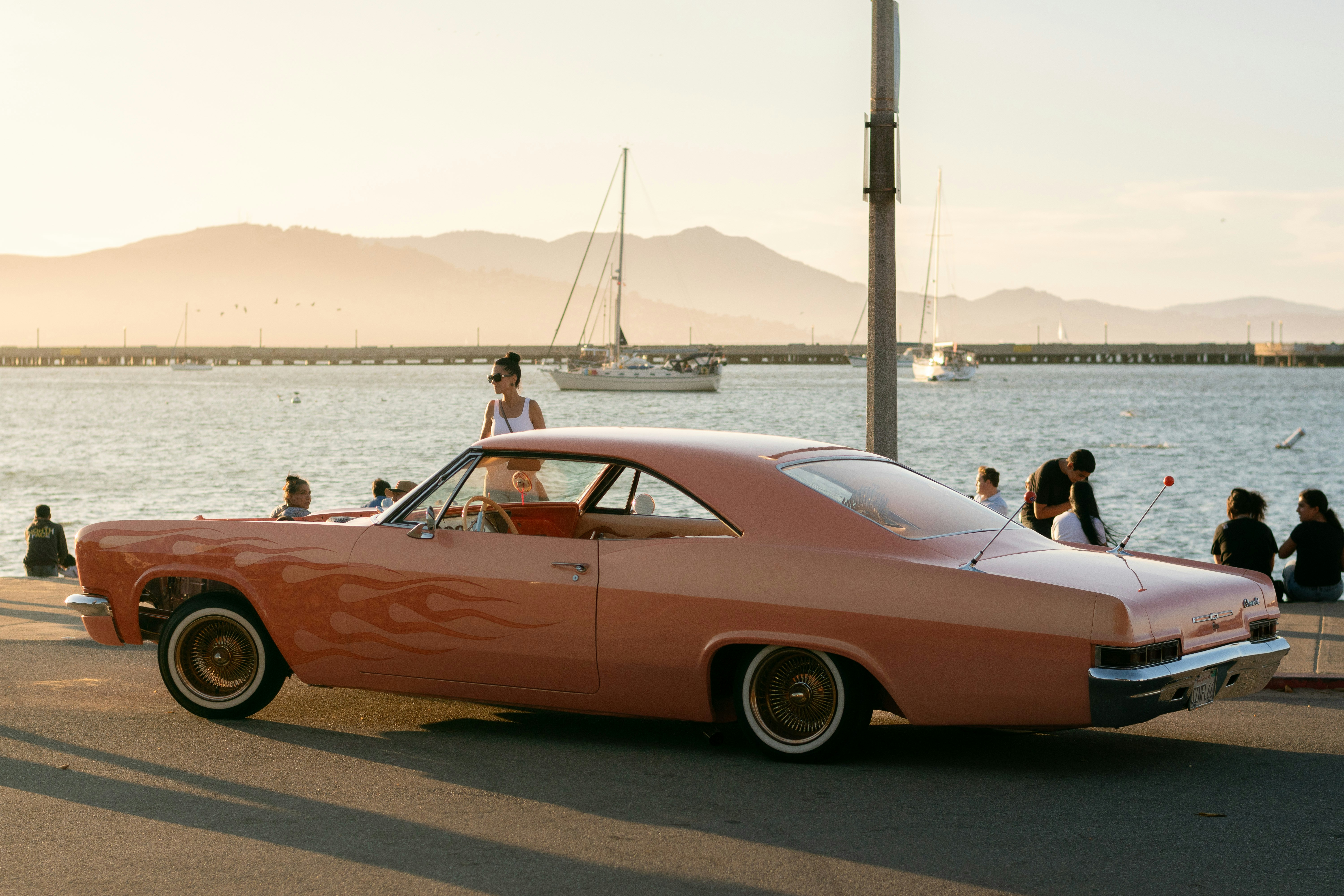  peach-colored classic cruising by the marina at golden hour