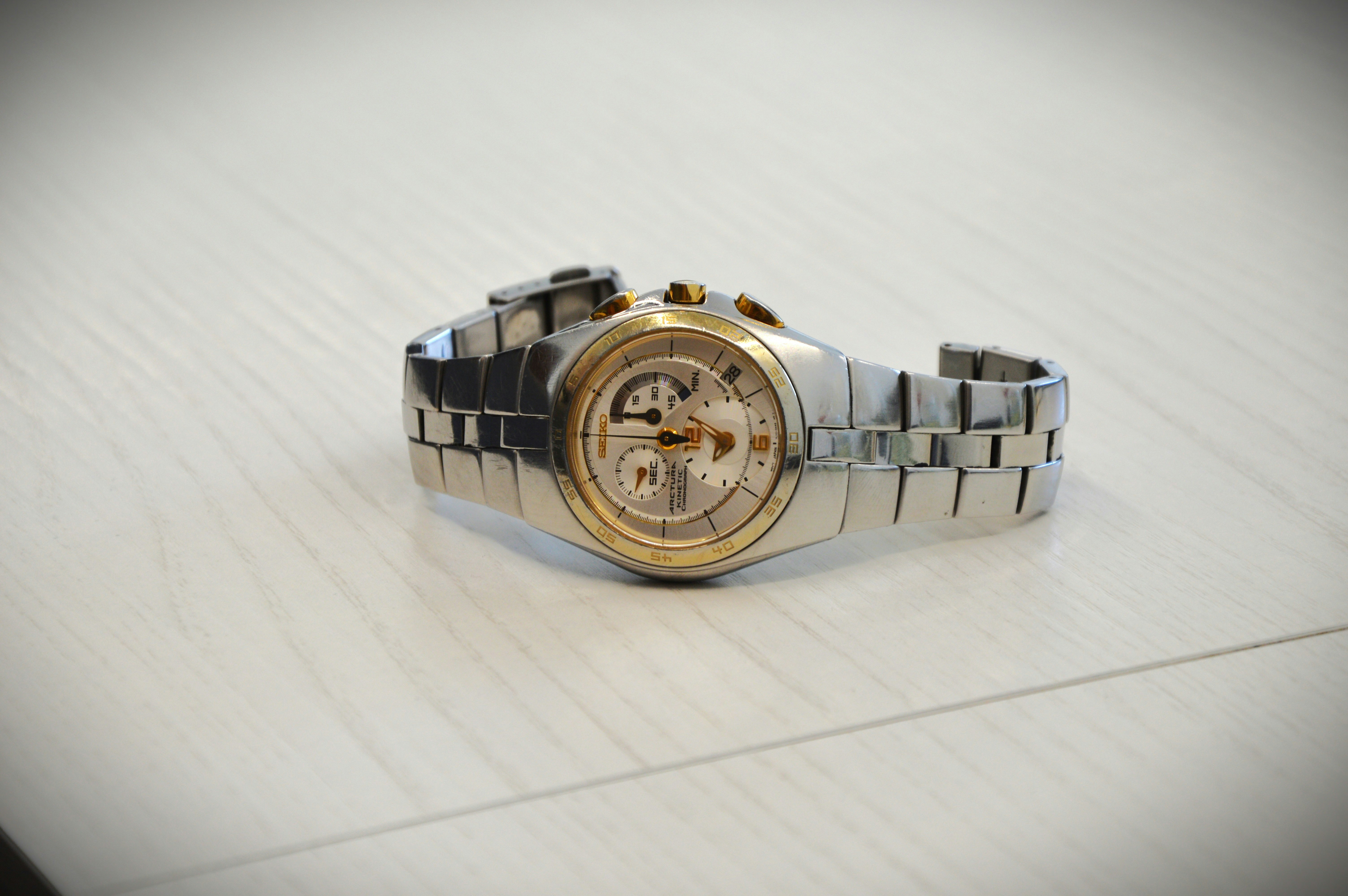 Metallic Timekeeper Resting on a Pale Floor