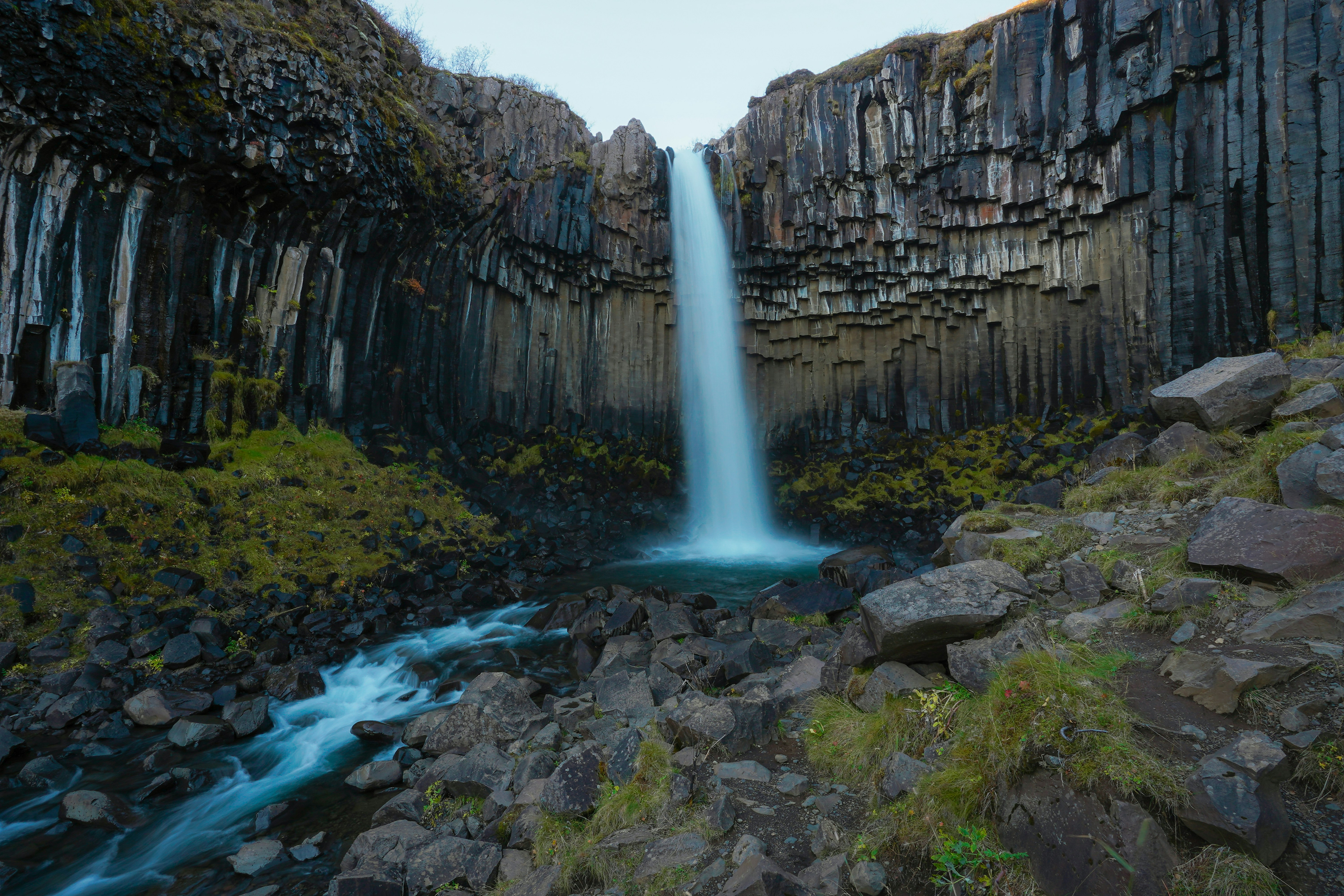Azure Veil: A Lone Cascade Descends the Basalt Cliffs