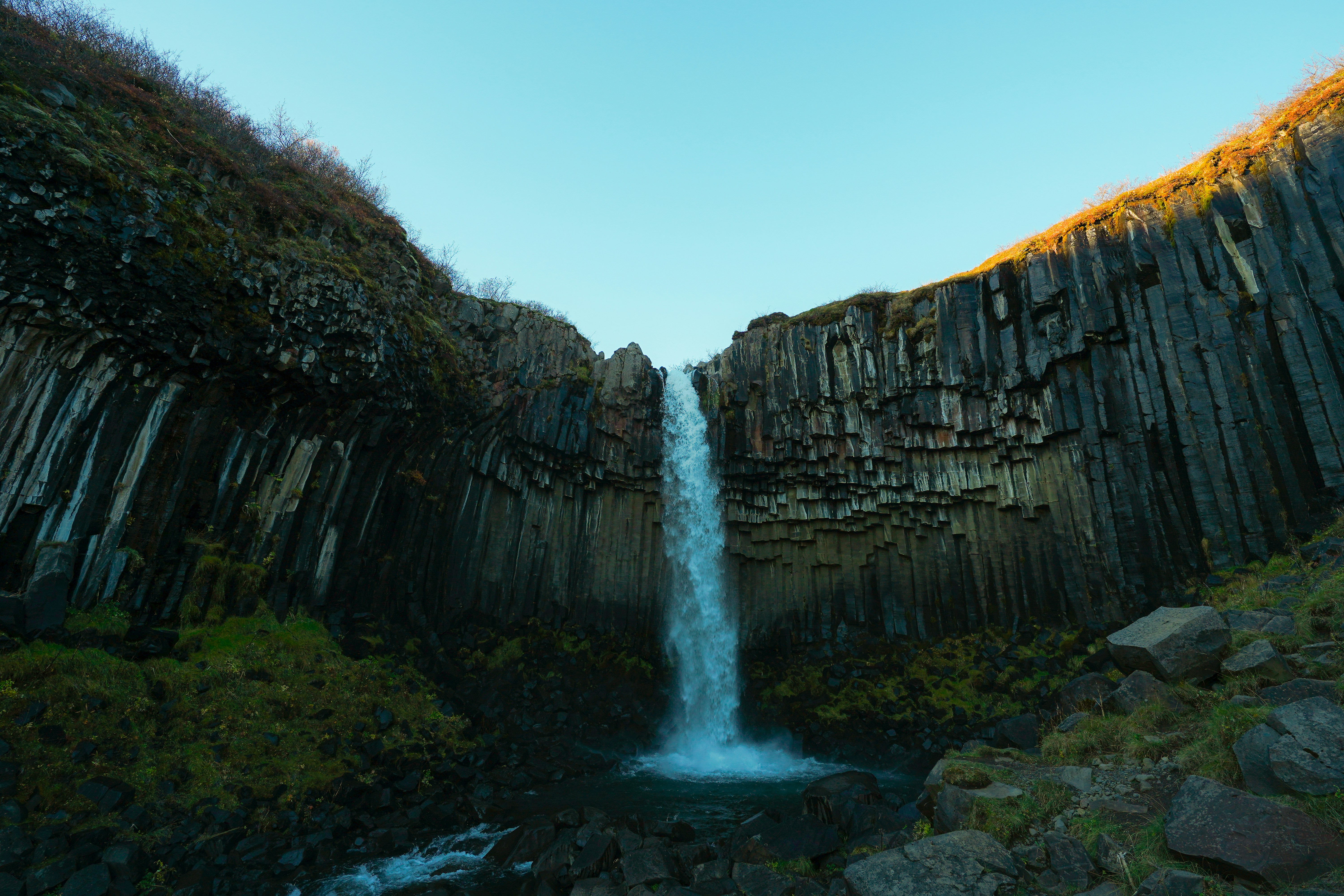 Vertical Veil: A Narrow Cascade Between Pillared Basalt Cliffs