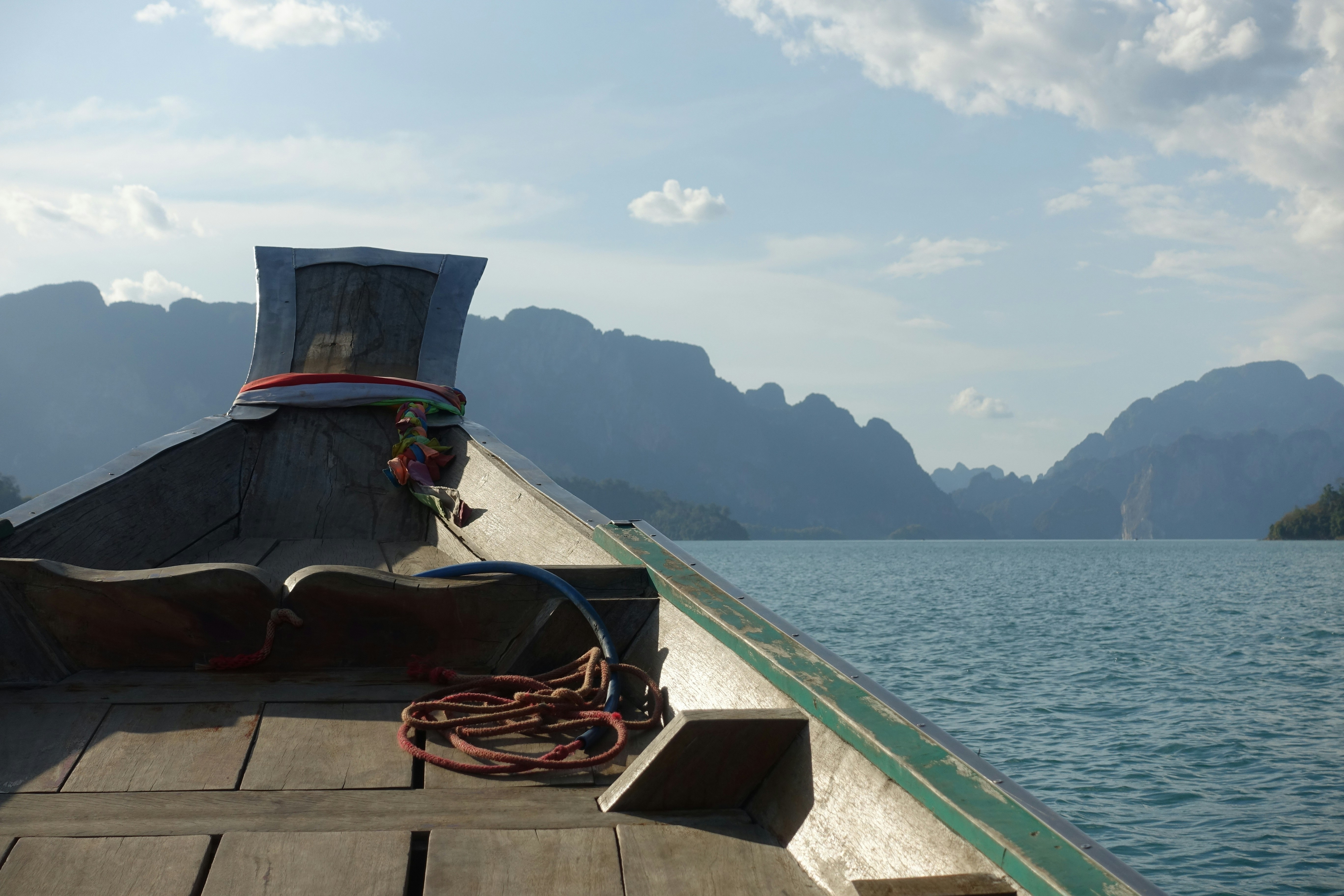 Forward View from a Wooden Boat toward Distant Peaks