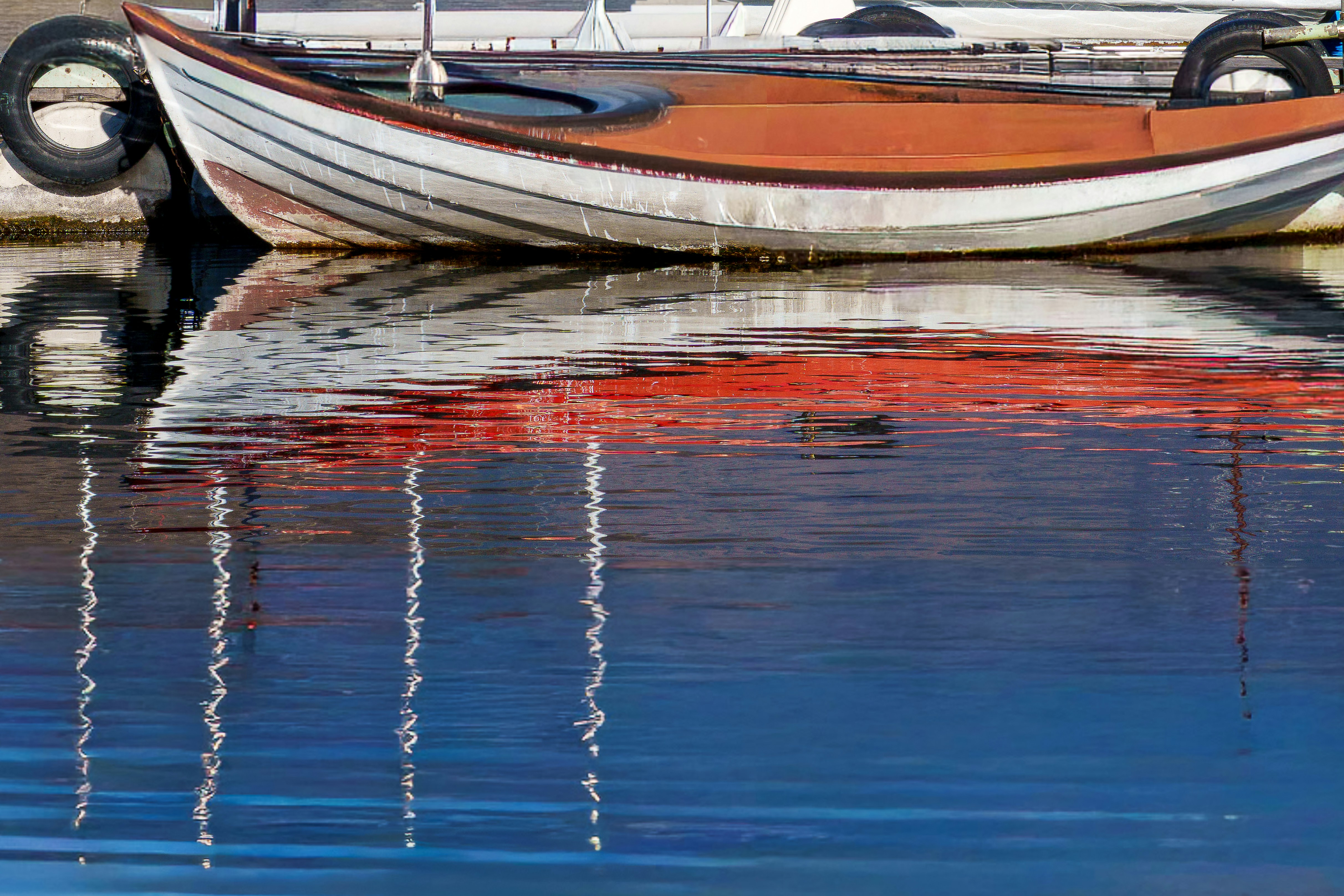 Red Boat on Glassy Blue Water