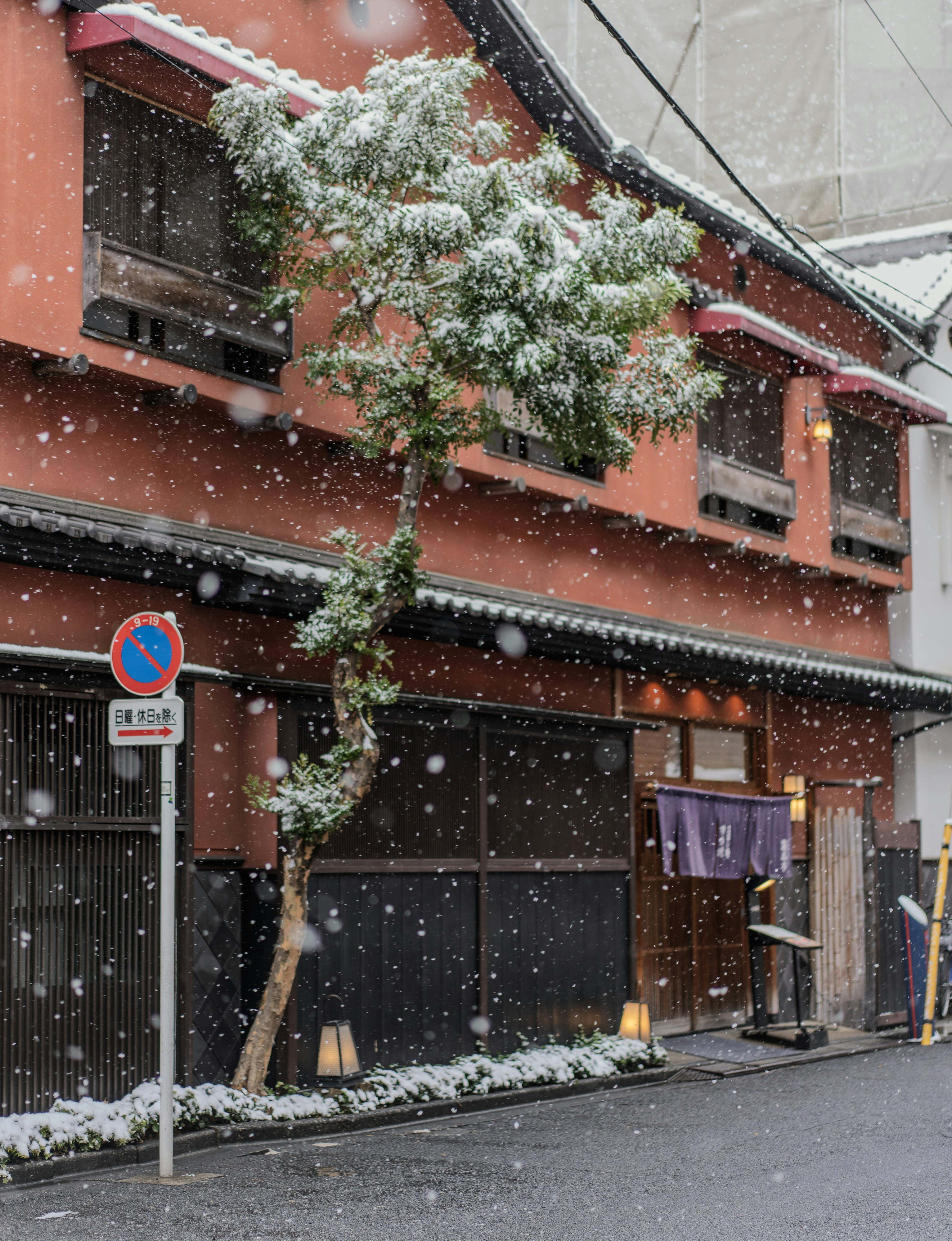 Snowfall Over a Warm-Orange Facade