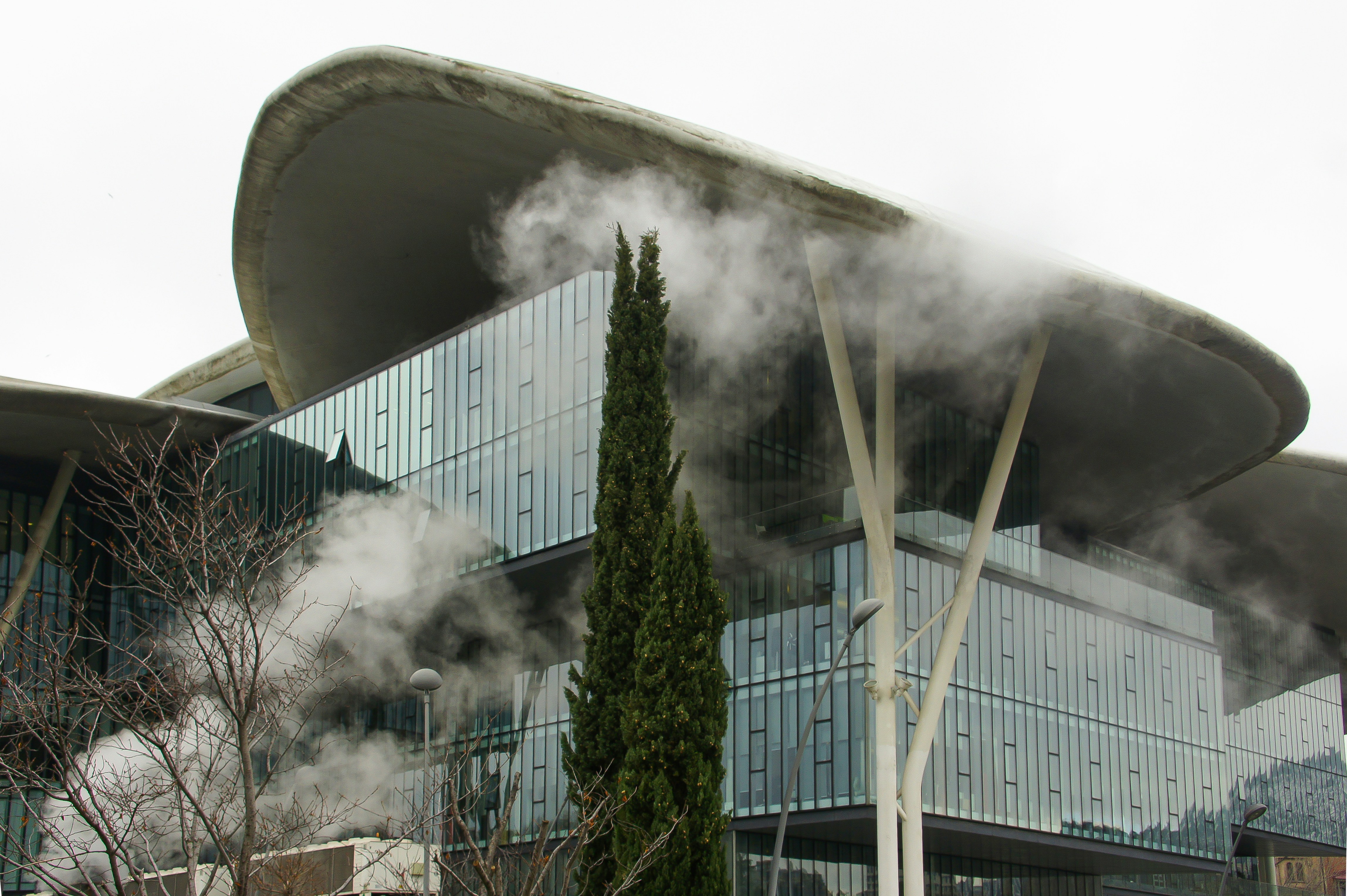 Sleek canopy and steam: a modern architectural marvel under breathy clouds