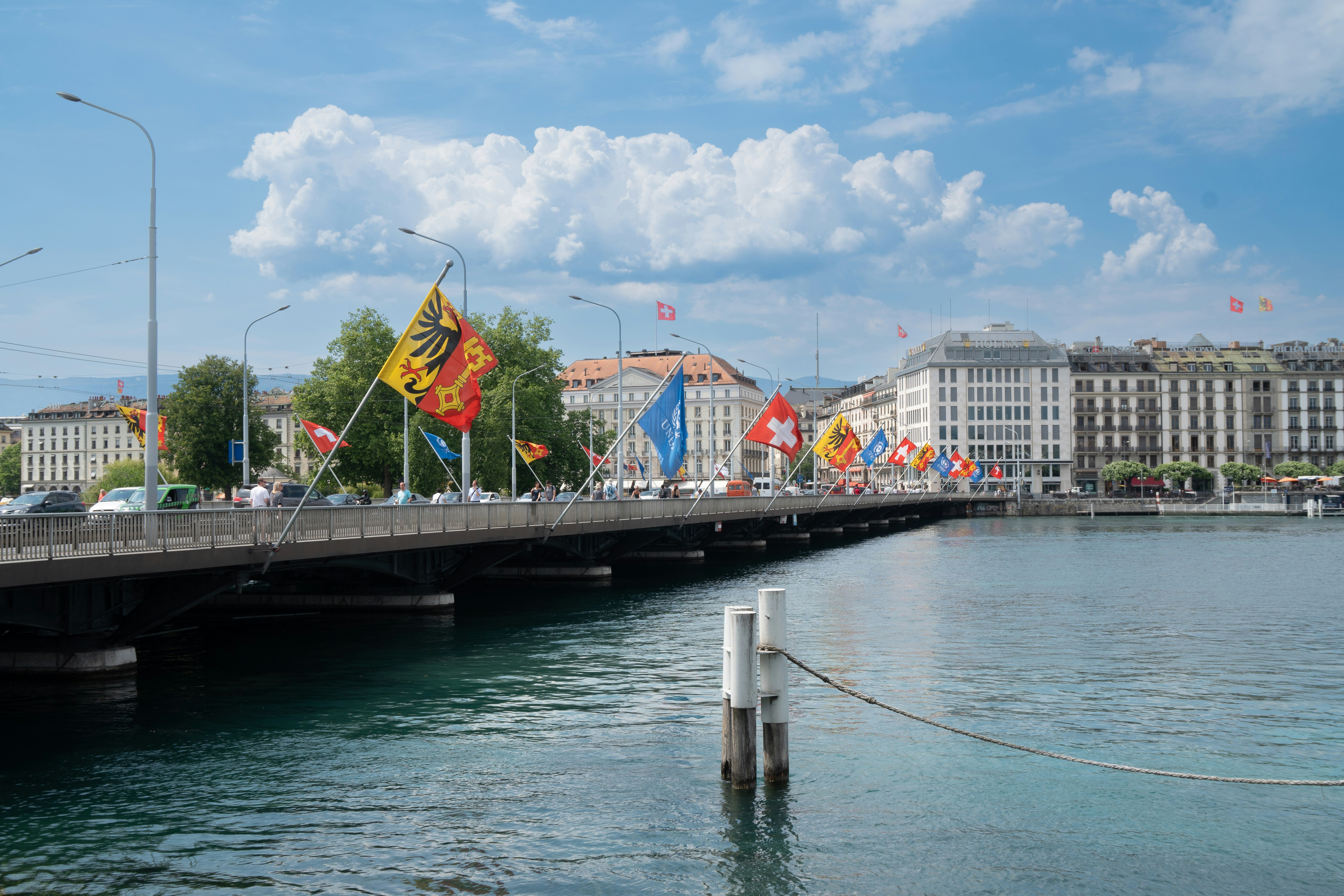 Flags along a sunlit Swiss-like harbor bridge