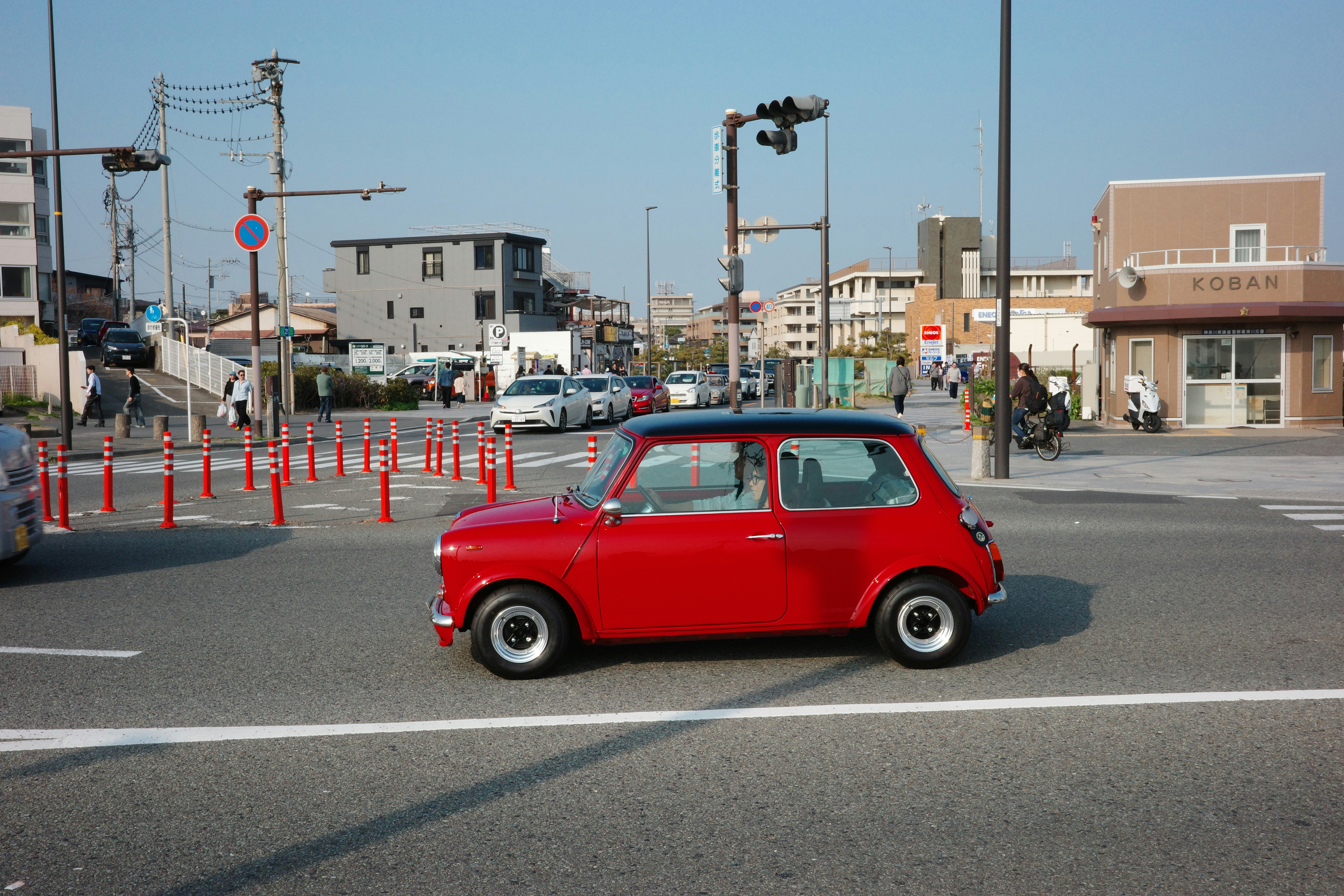 Red Microcar on a Quiet Urban Crossing