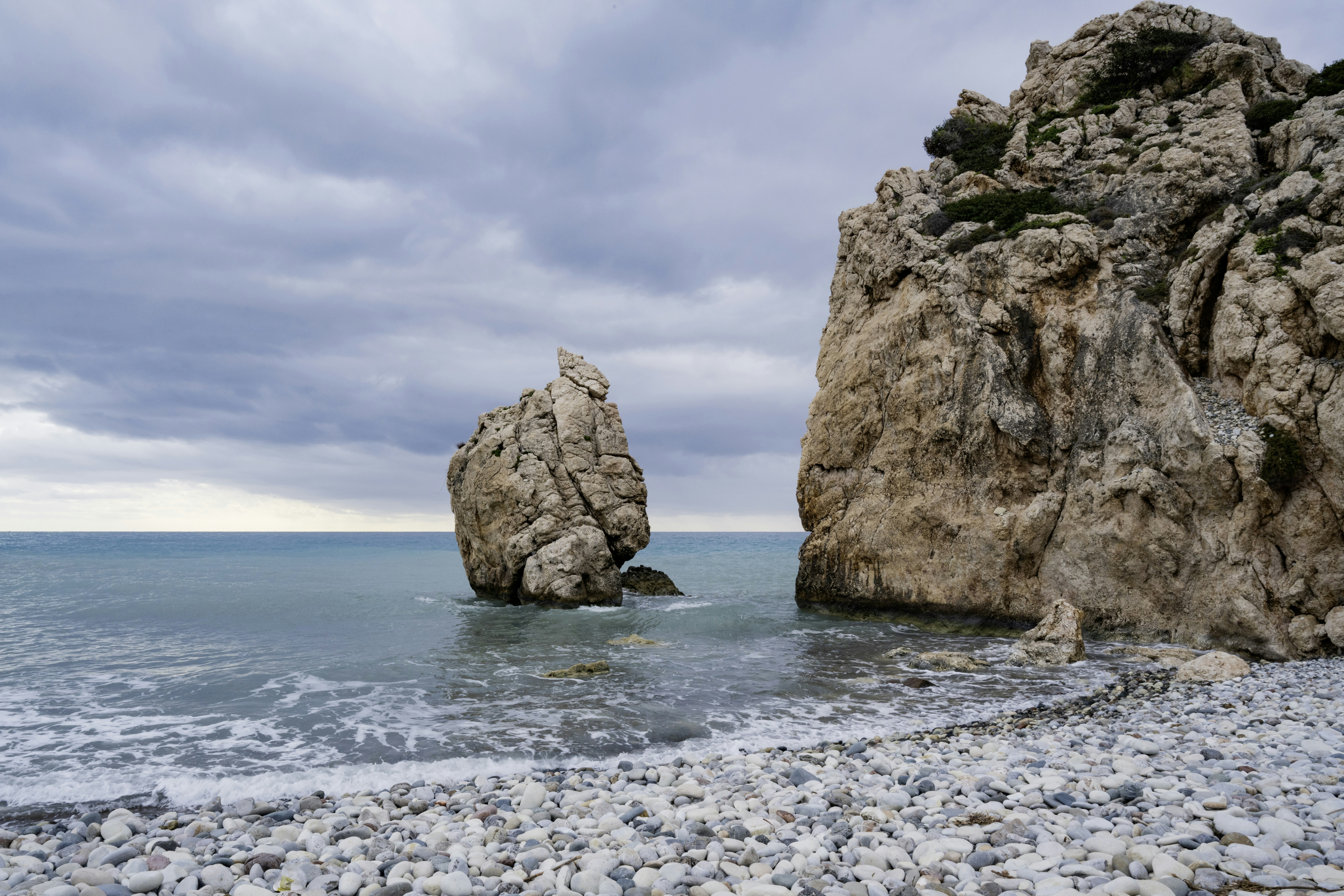 Sea Gate at Distant Arch: A Pebble Beach Framing Two Coastal Giants