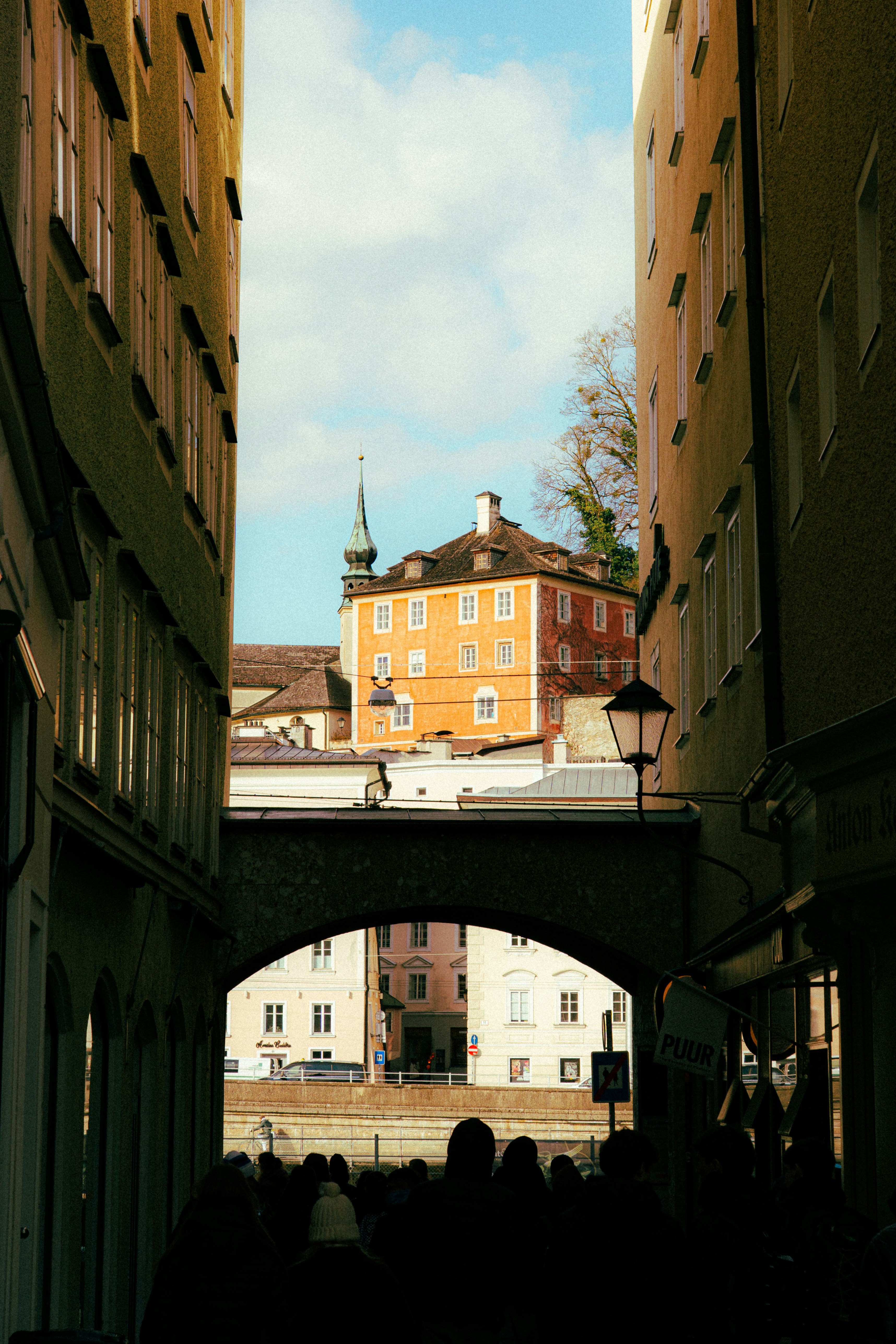 Sunlit Townhouse Rising Between Shadowed Archways