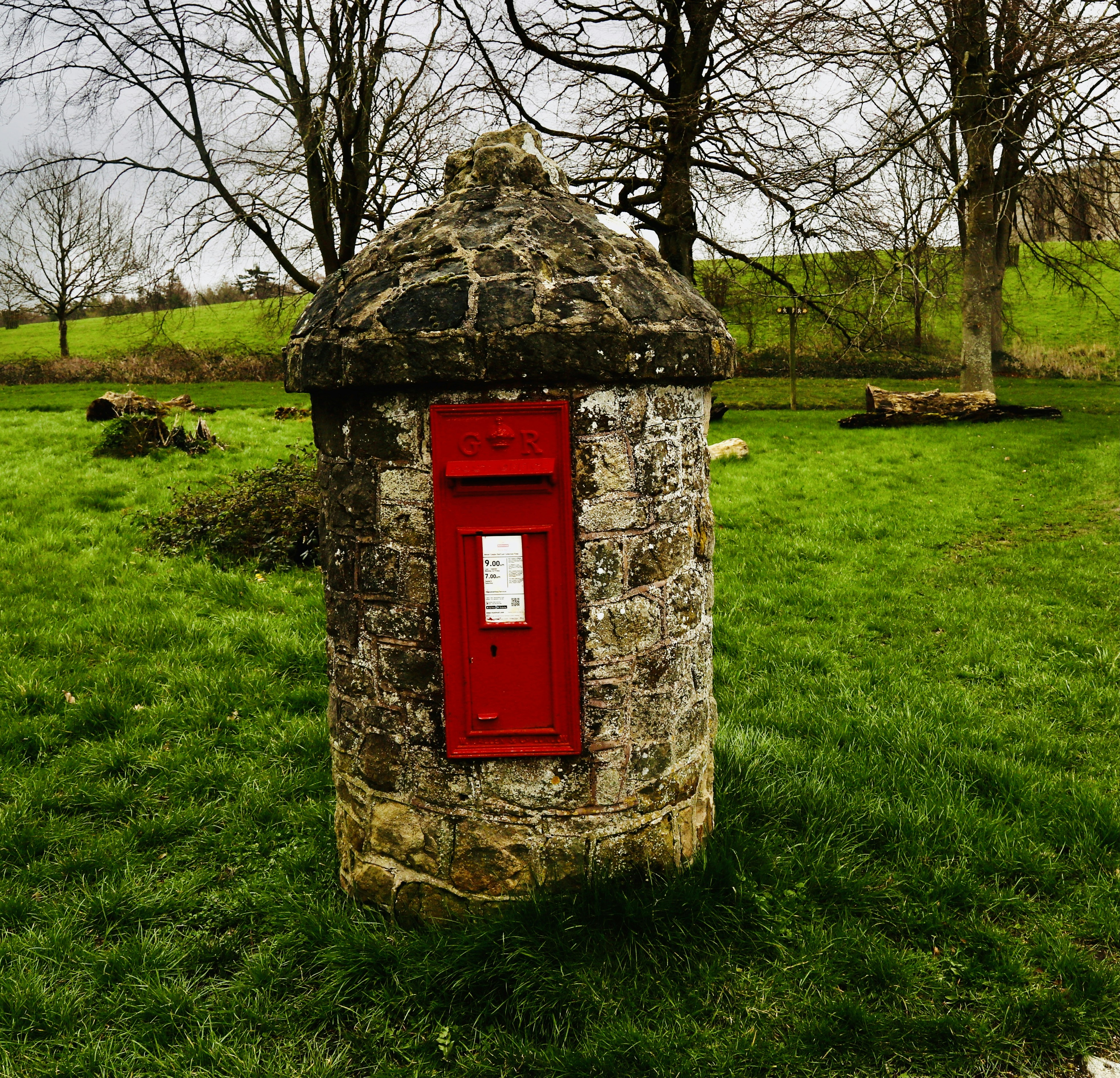 Red Mailbox on a Stone Sentinel in a Green Meadow