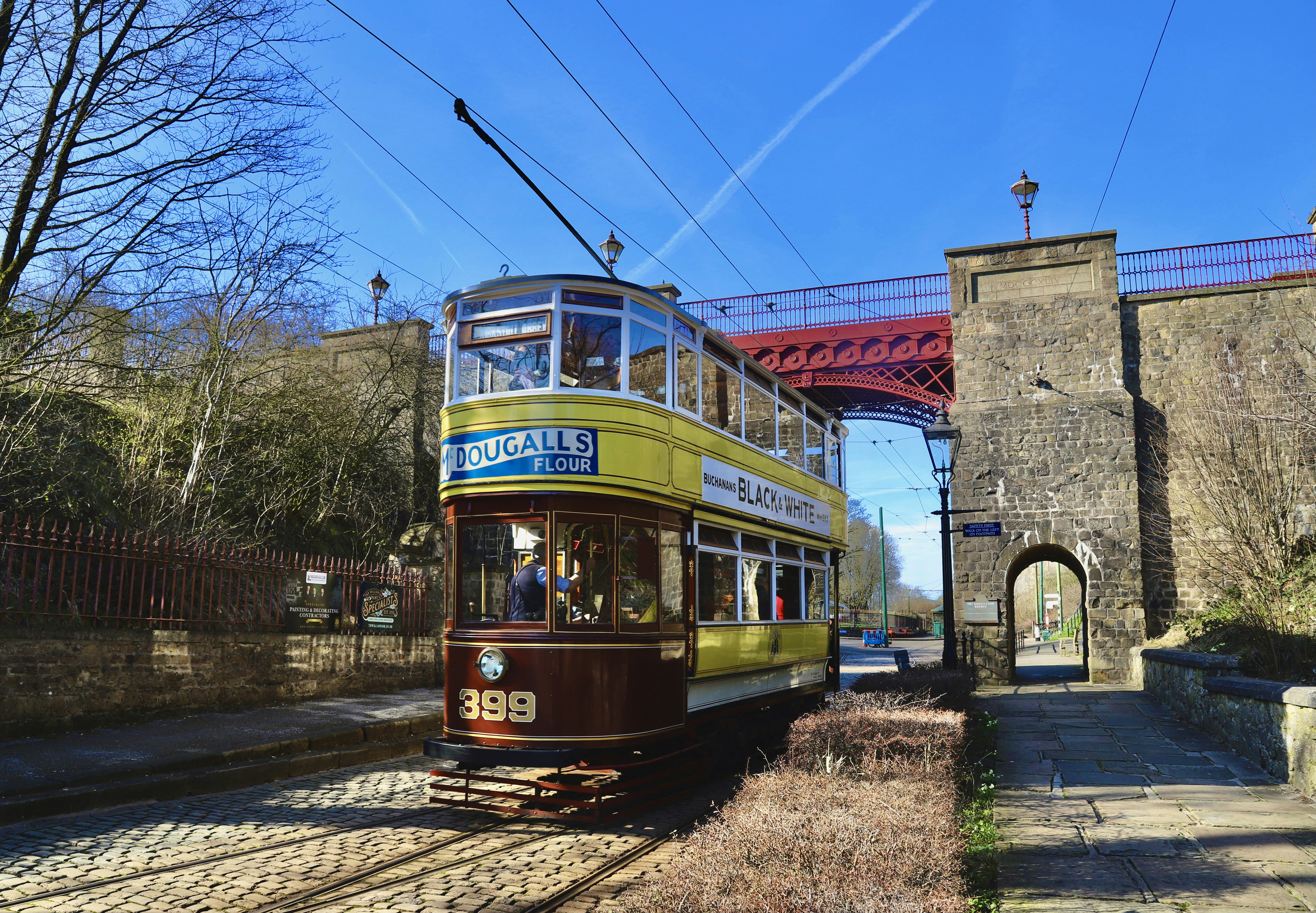 Heritage Streak: The Red and Cream Tram Beneath the Stone Arch
