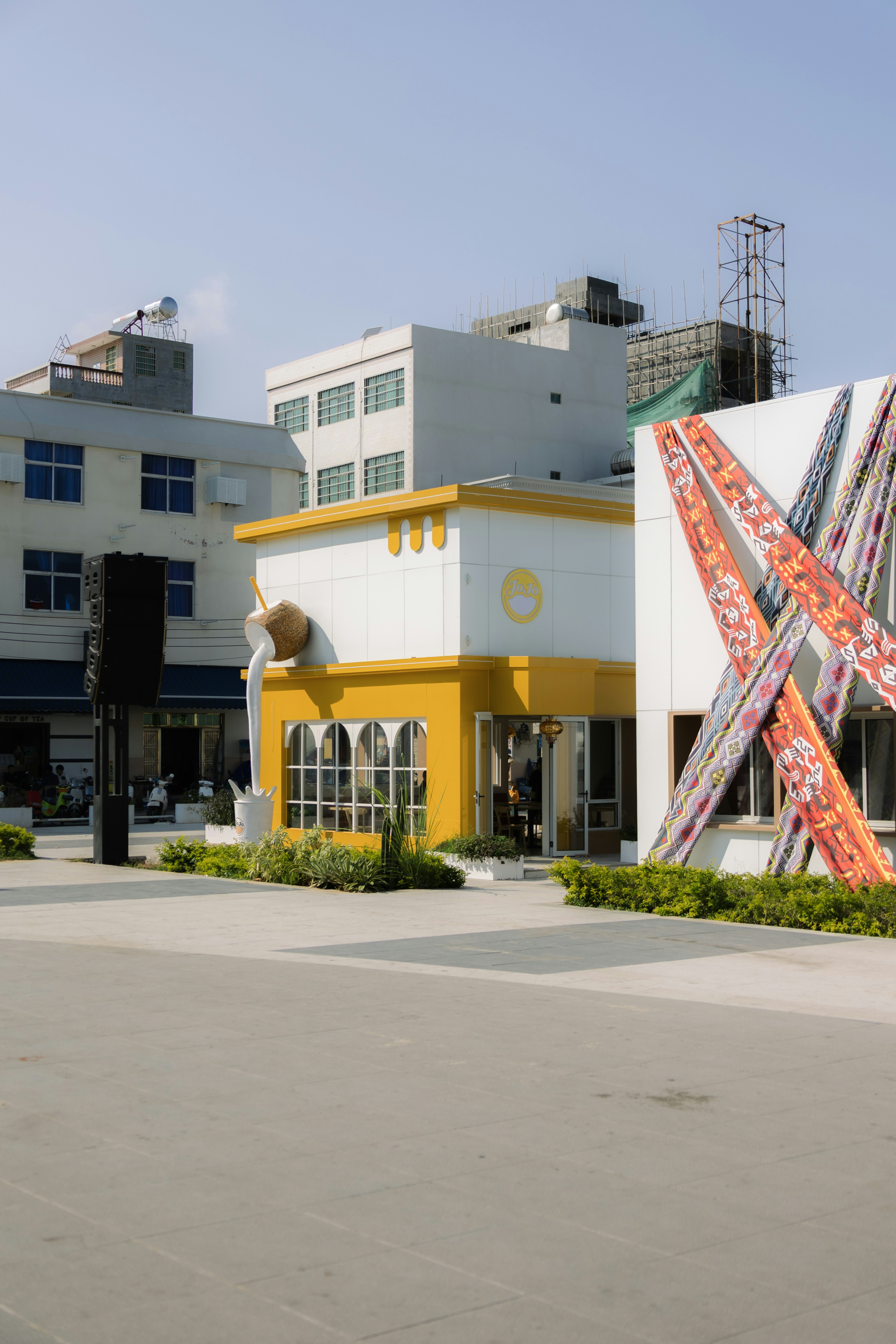 Yellow Café Pavilion Anchored by an Artistically Draped Sculpture
