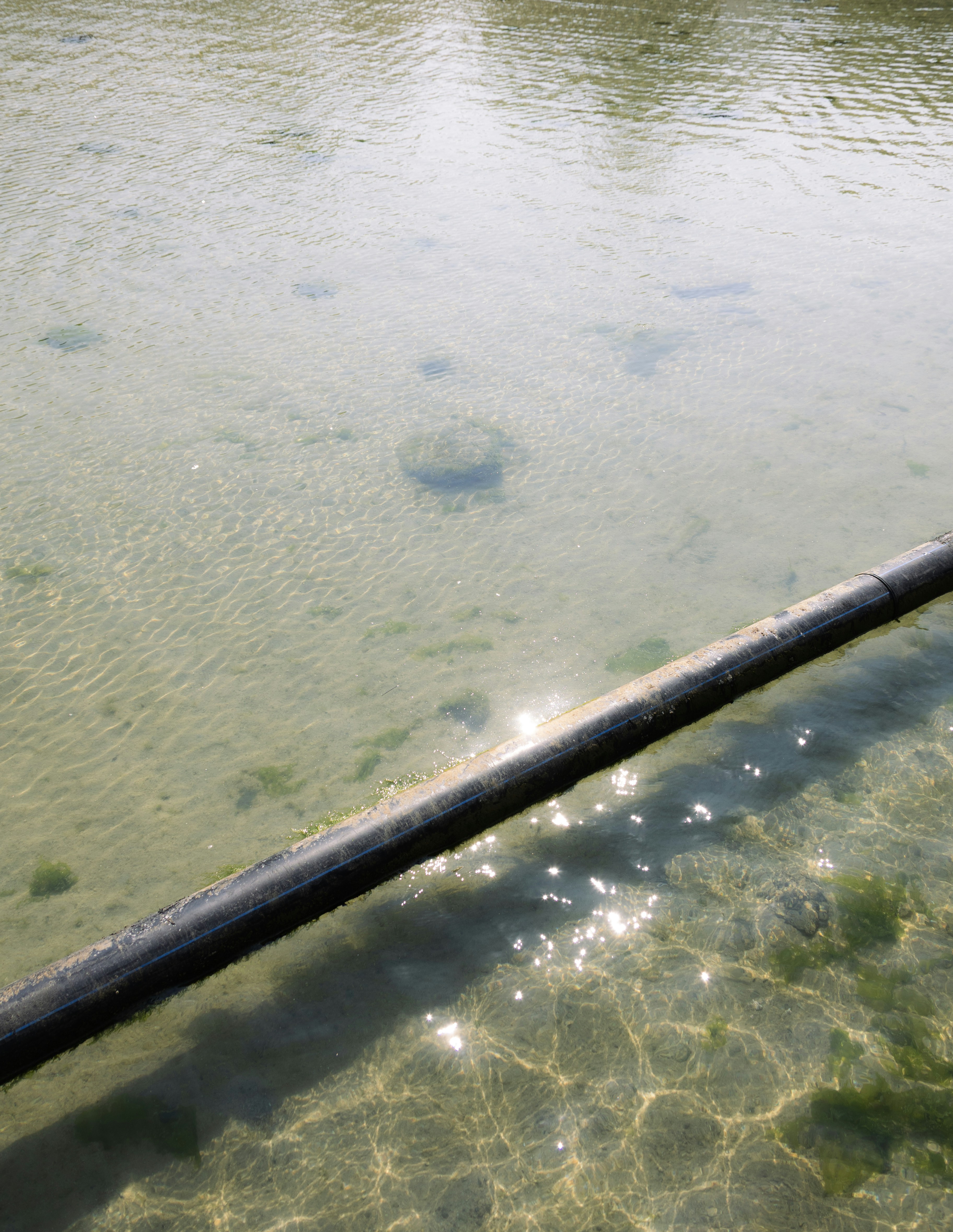 Glassy Riverbed and a Floating Pipe