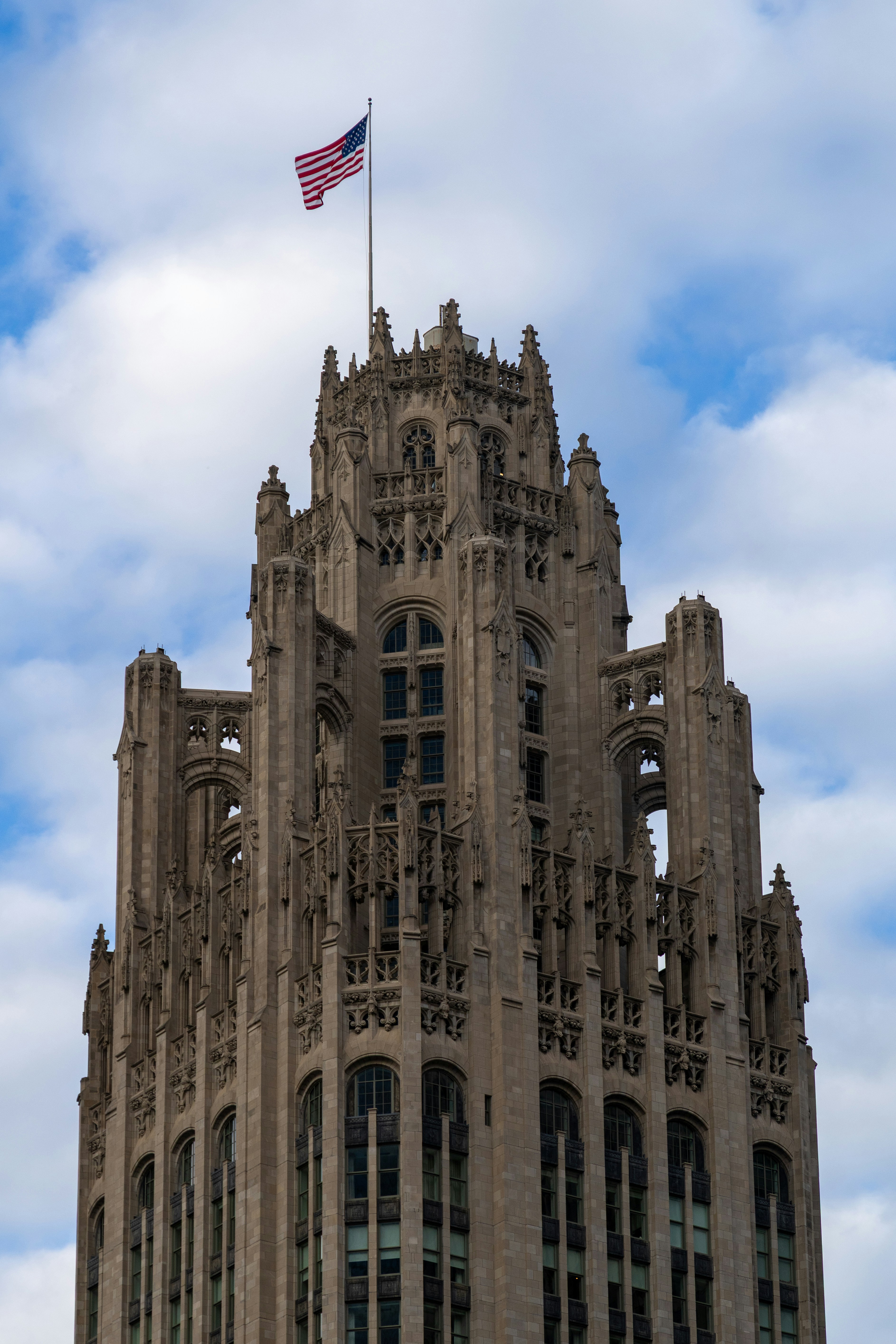 Flag atop Gothic Tower Reaching Toward a Bright Sky