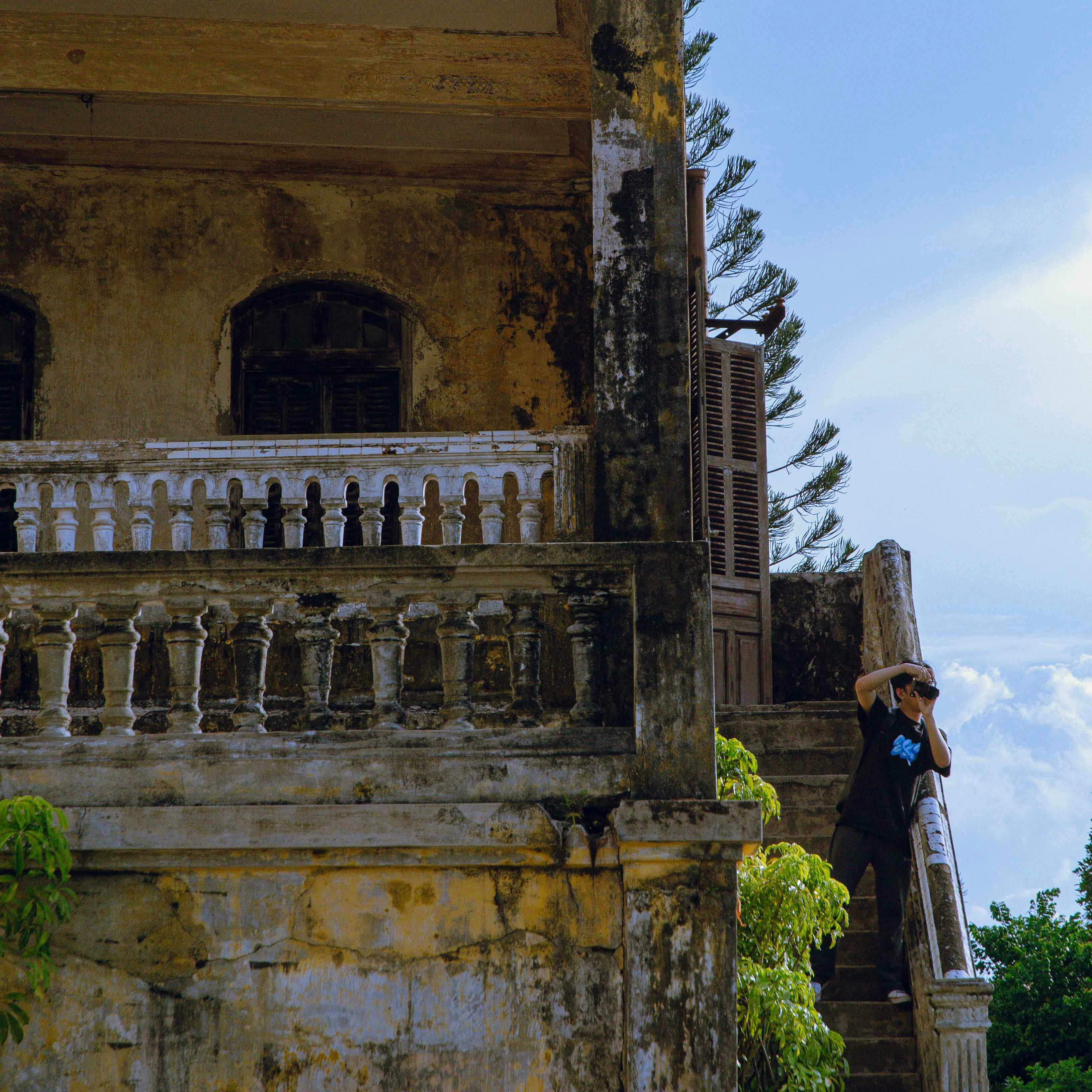 Weathered villa silhouette: a visitor on the stairway to a sunlit horizon