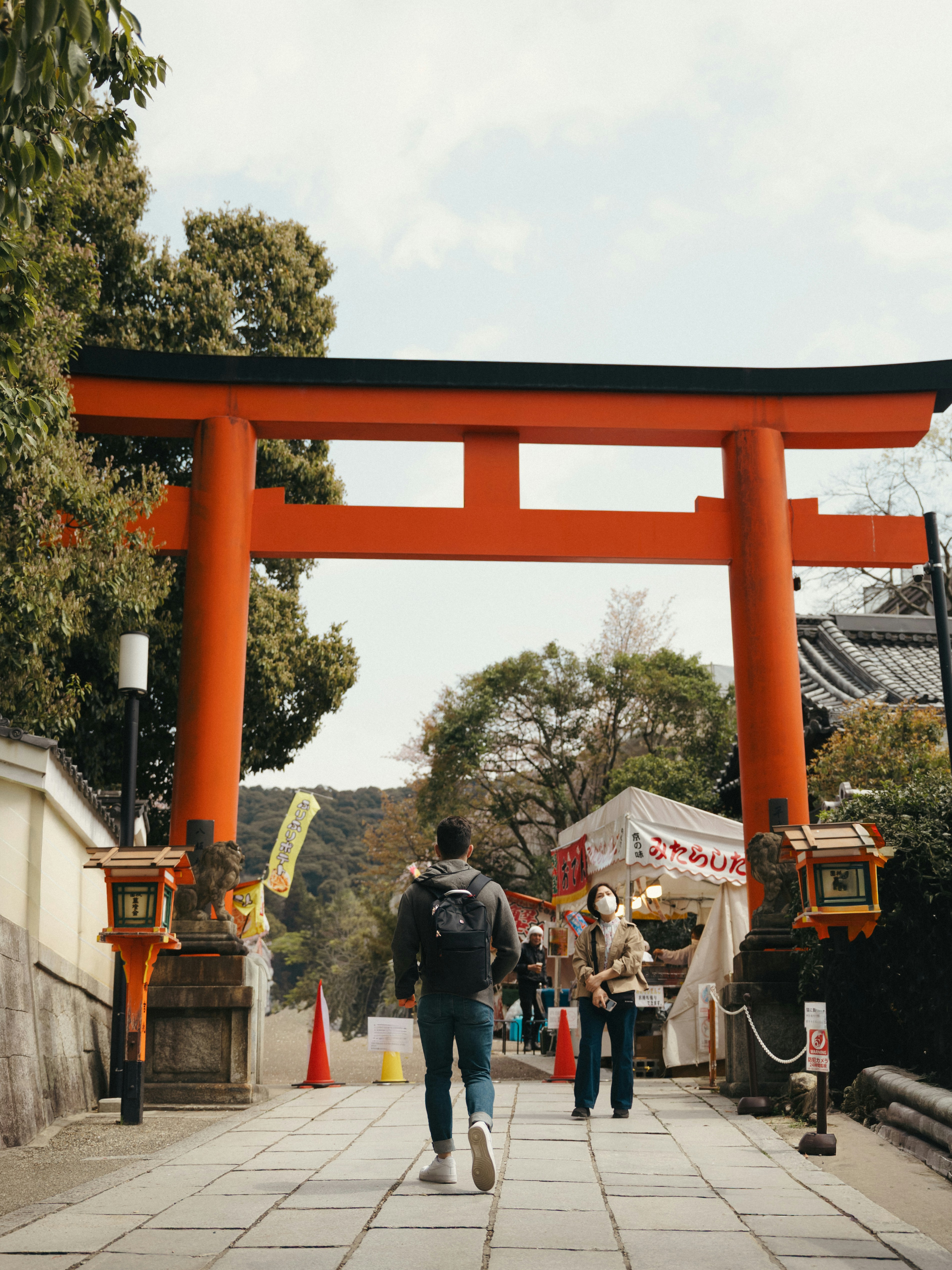 Red Torii Gate Pathway: People Entering a Shinto Shrine