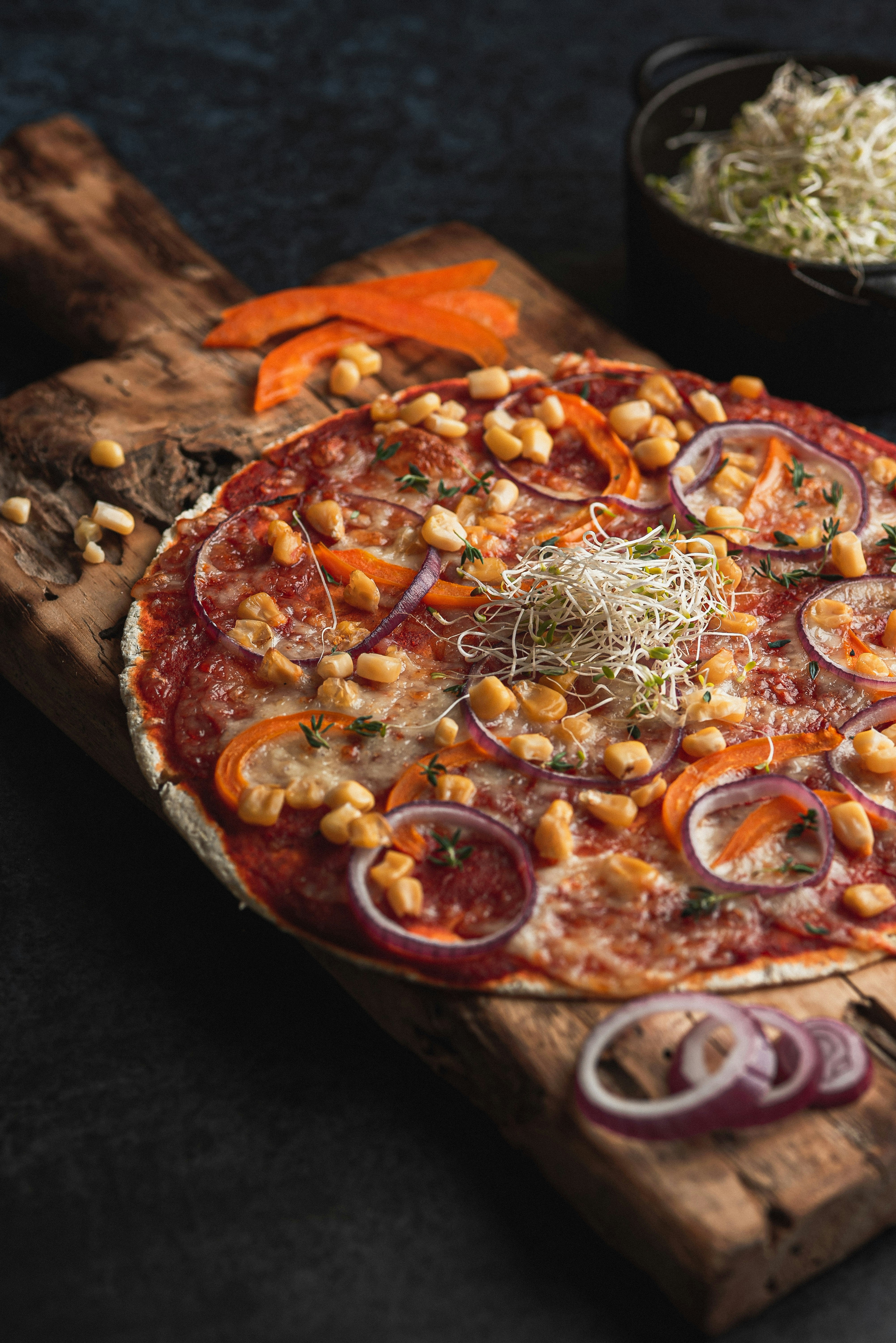 Charred Crust Pizza on a Rustic Board with Neon Sprouts