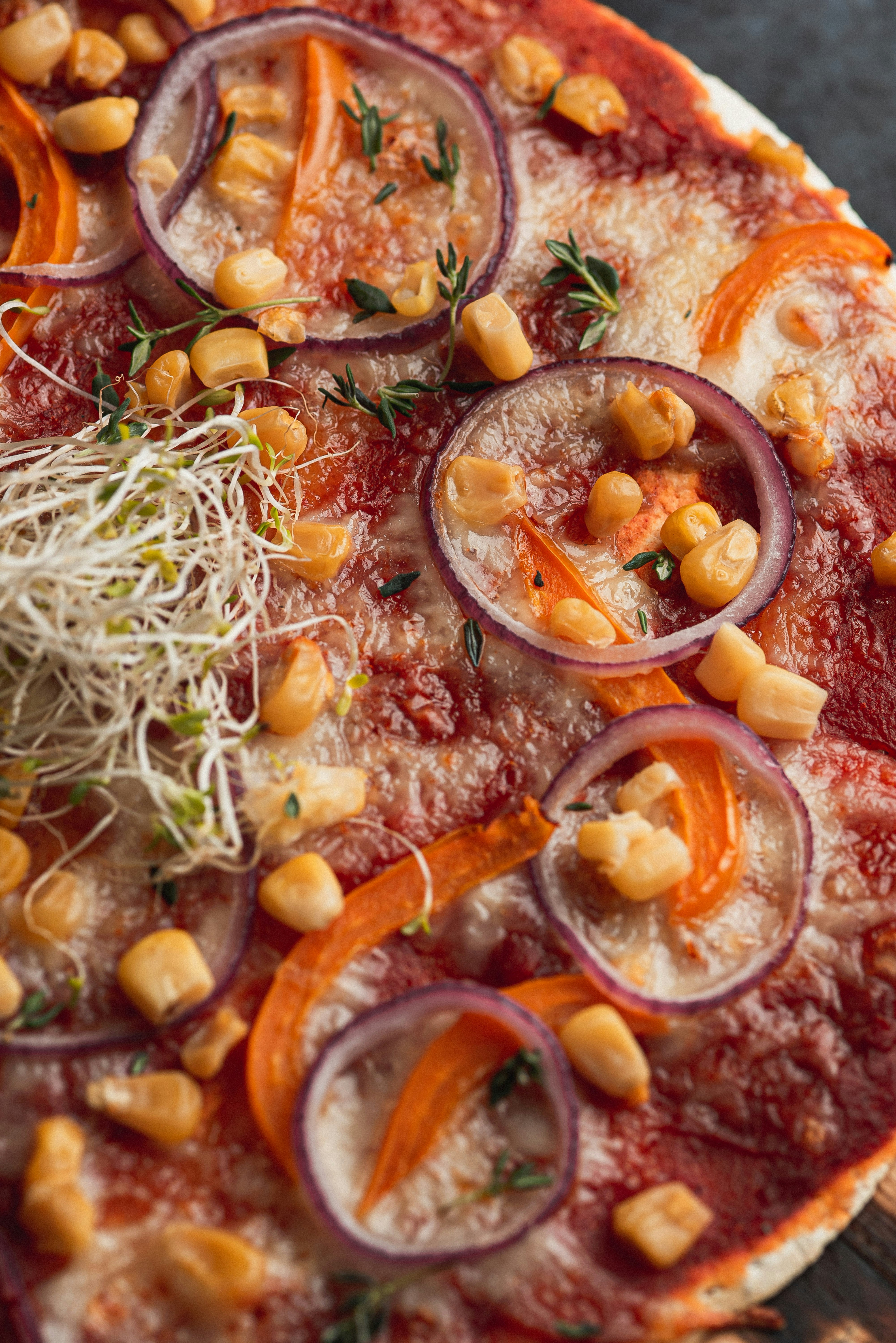 Gleaming Pepperoni Pizza Close-Up with Red Onion Rings and Greens