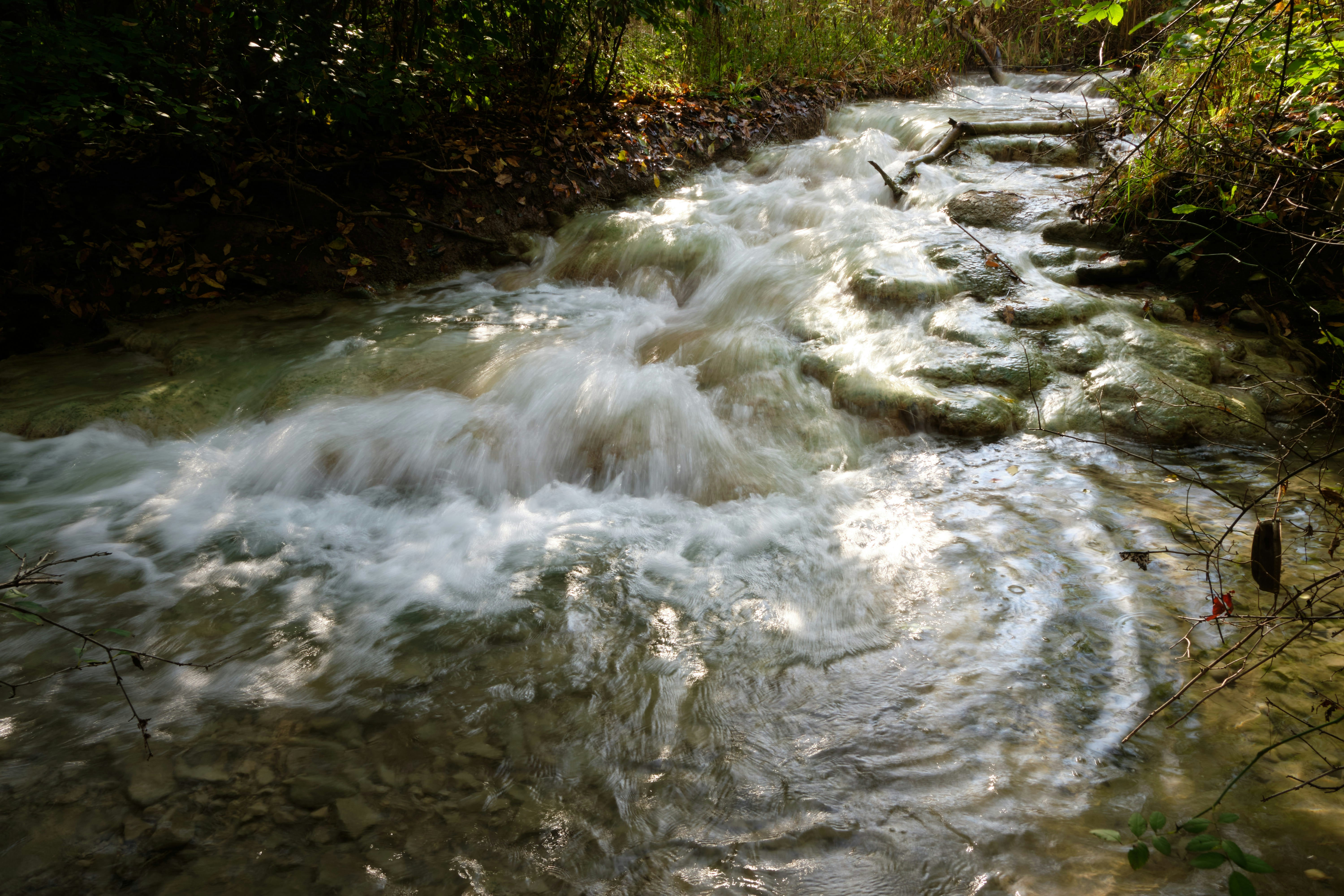 Whispering Cascade: Sunlit Ripples over Granite Steps
