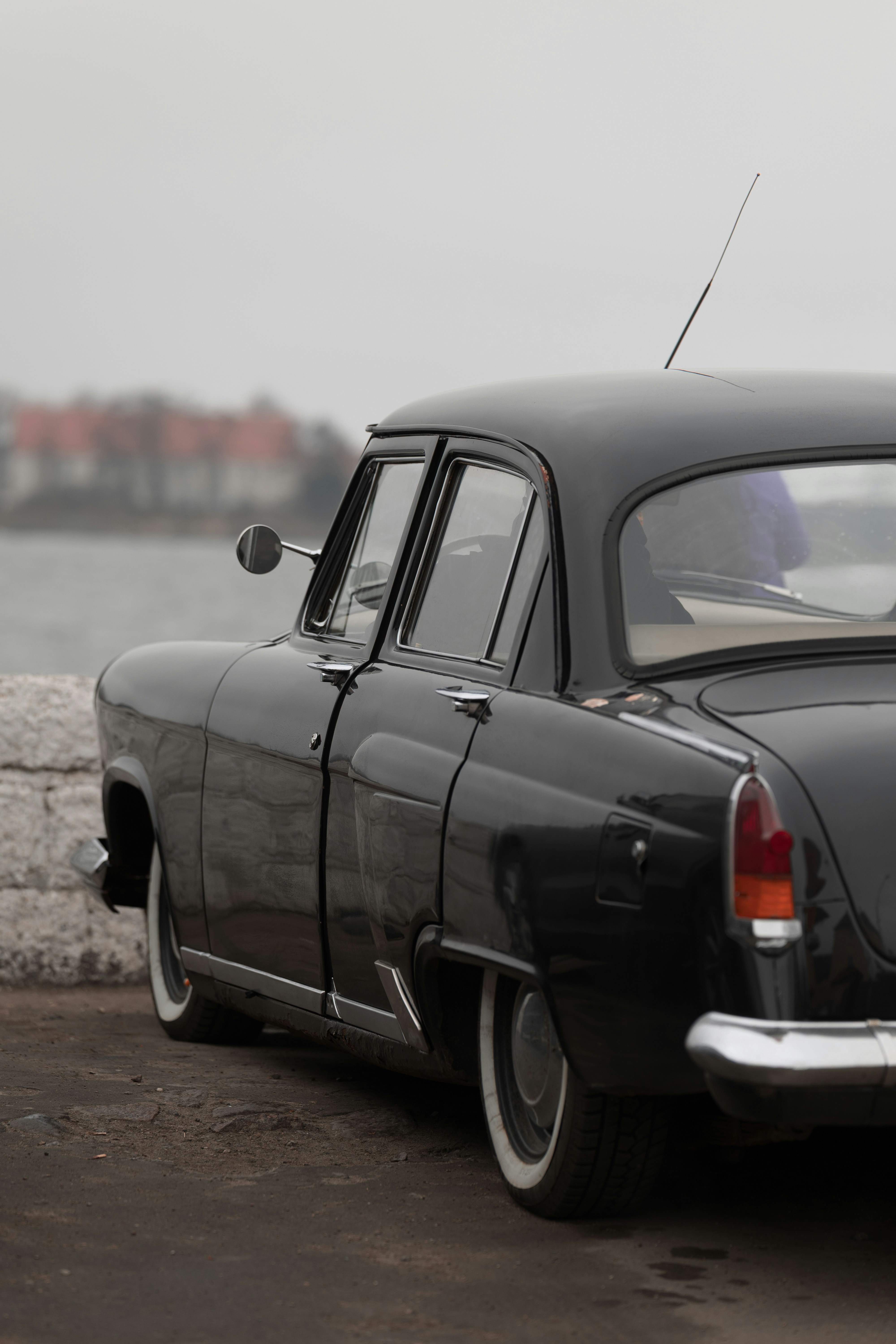 Vintage Torque by the Sea: A Classic Car Quietly Anchored Against the Pier