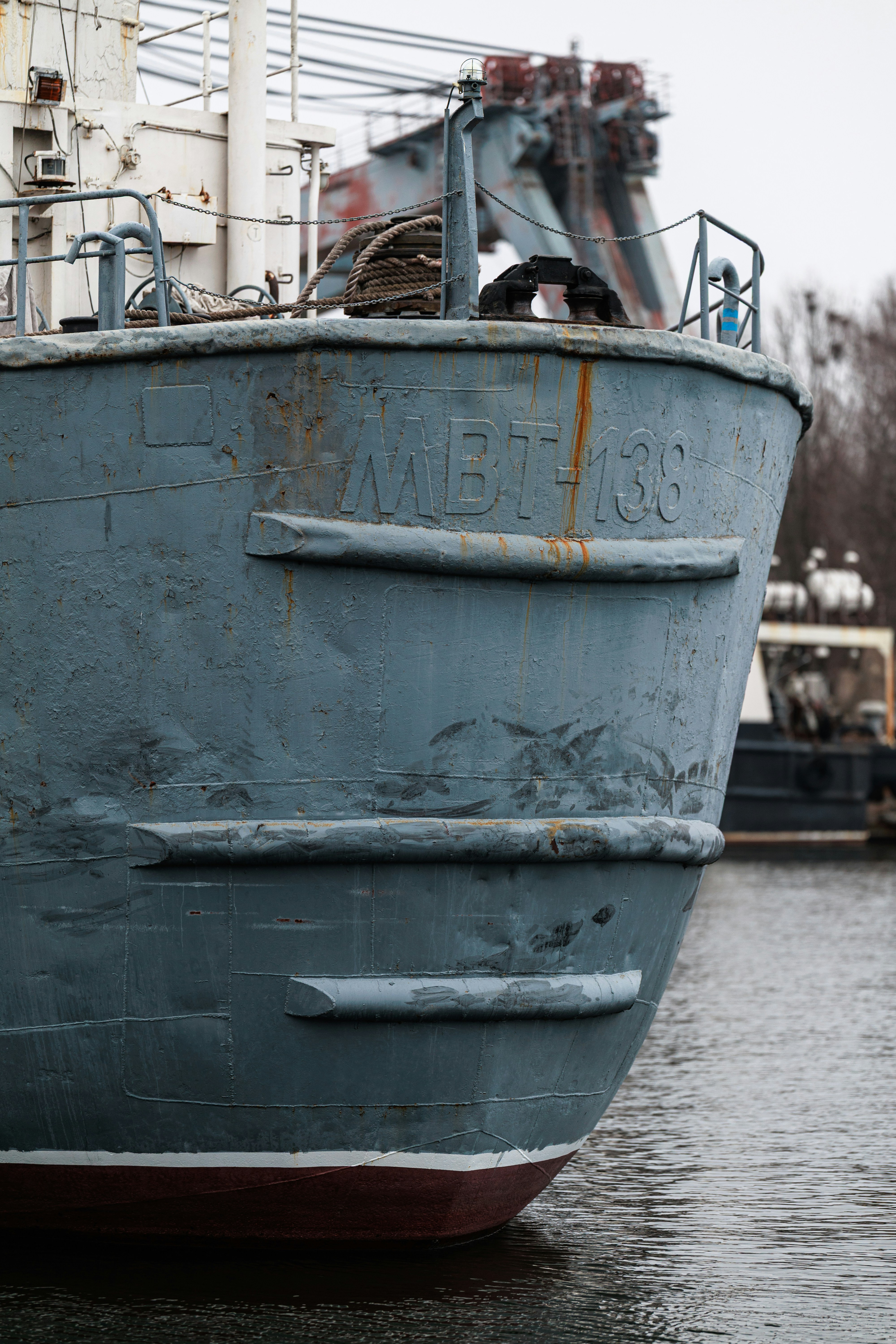Bowed Hull, Weathered Crane: A Portrait of a Quiet Harbor Vessel