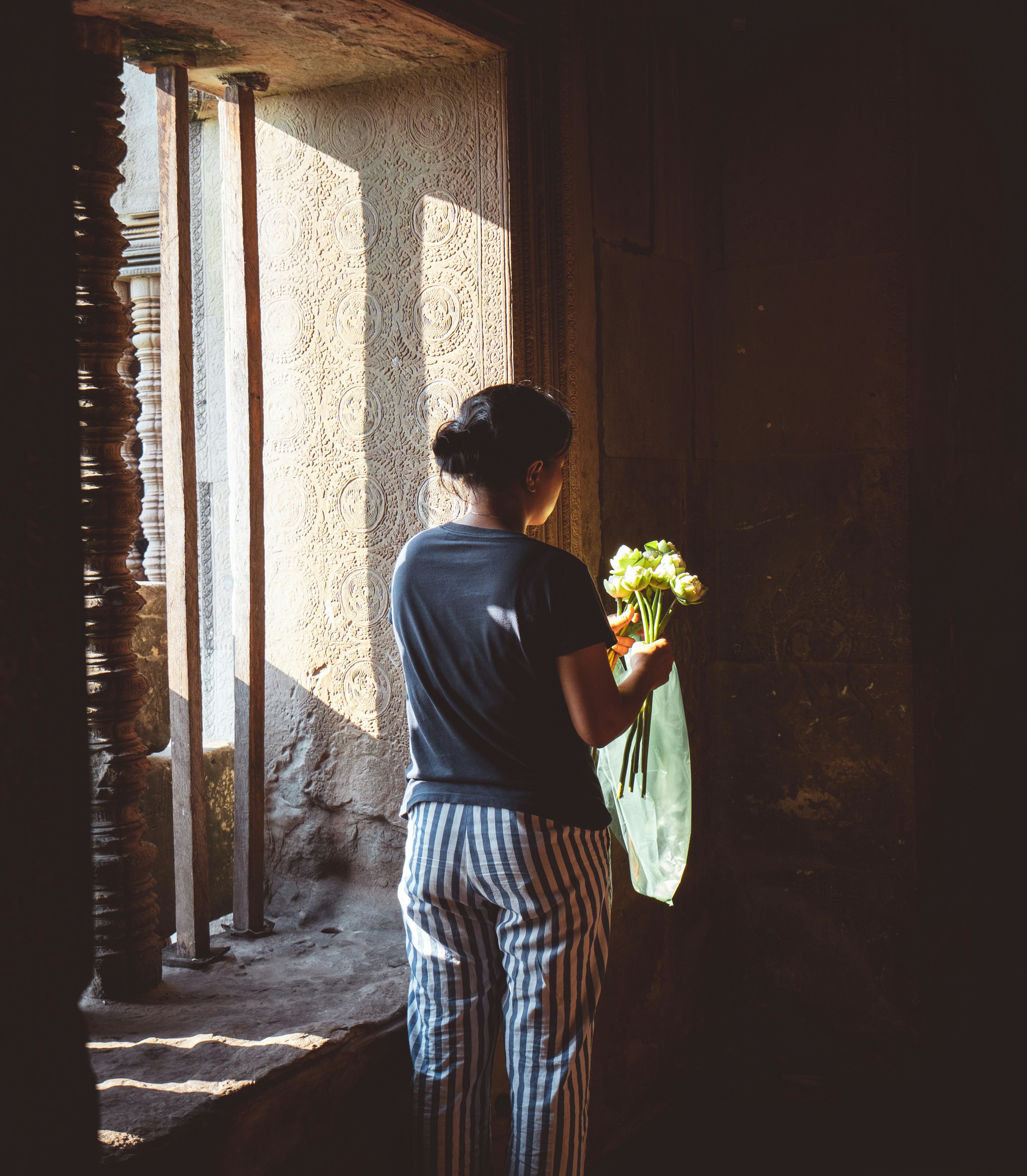 Quiet Offering: A Girl in Soft Light Presents Flowers by the Window