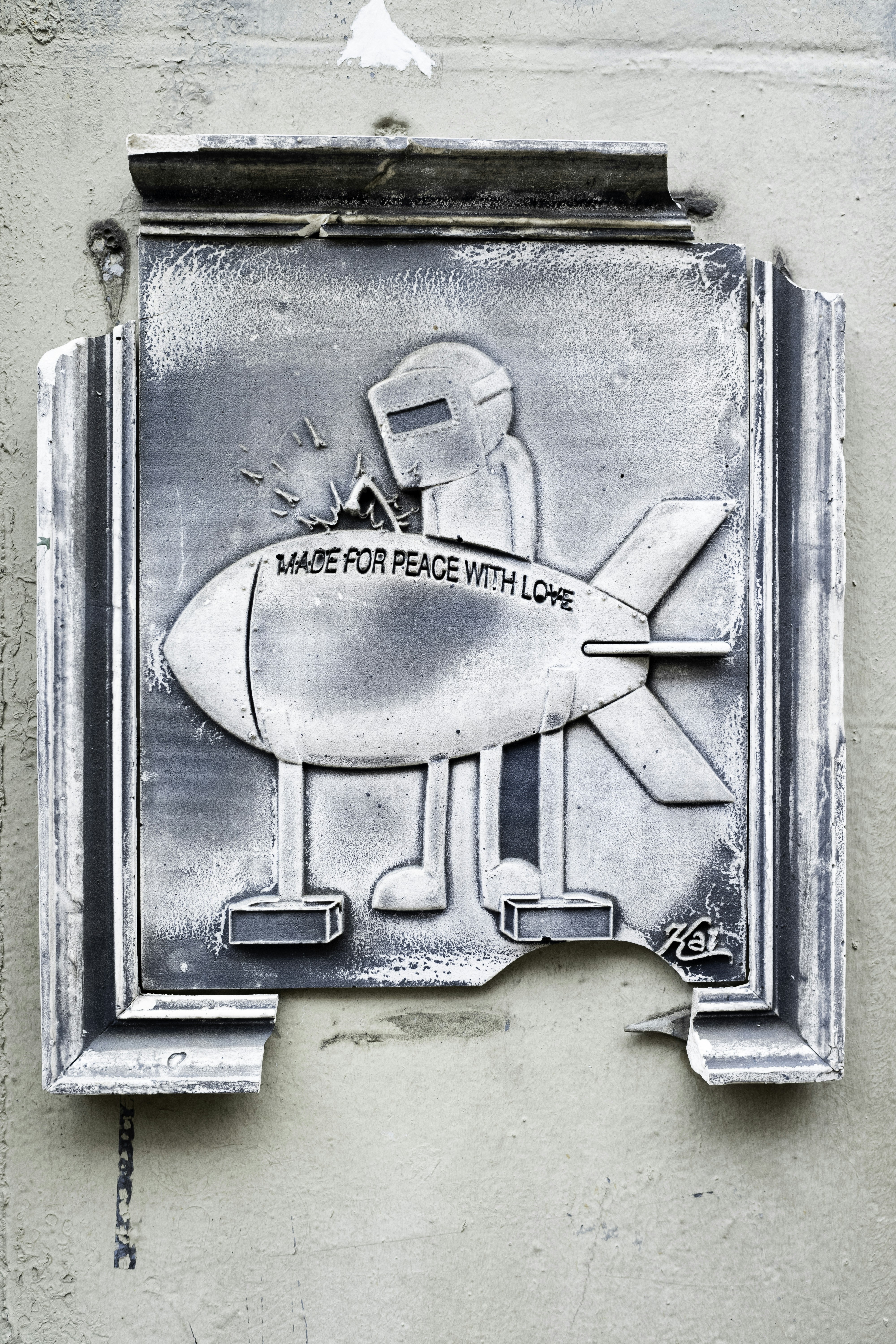 Peace Engine: A Weathered Graffiti Relief Surfaces on Concrete