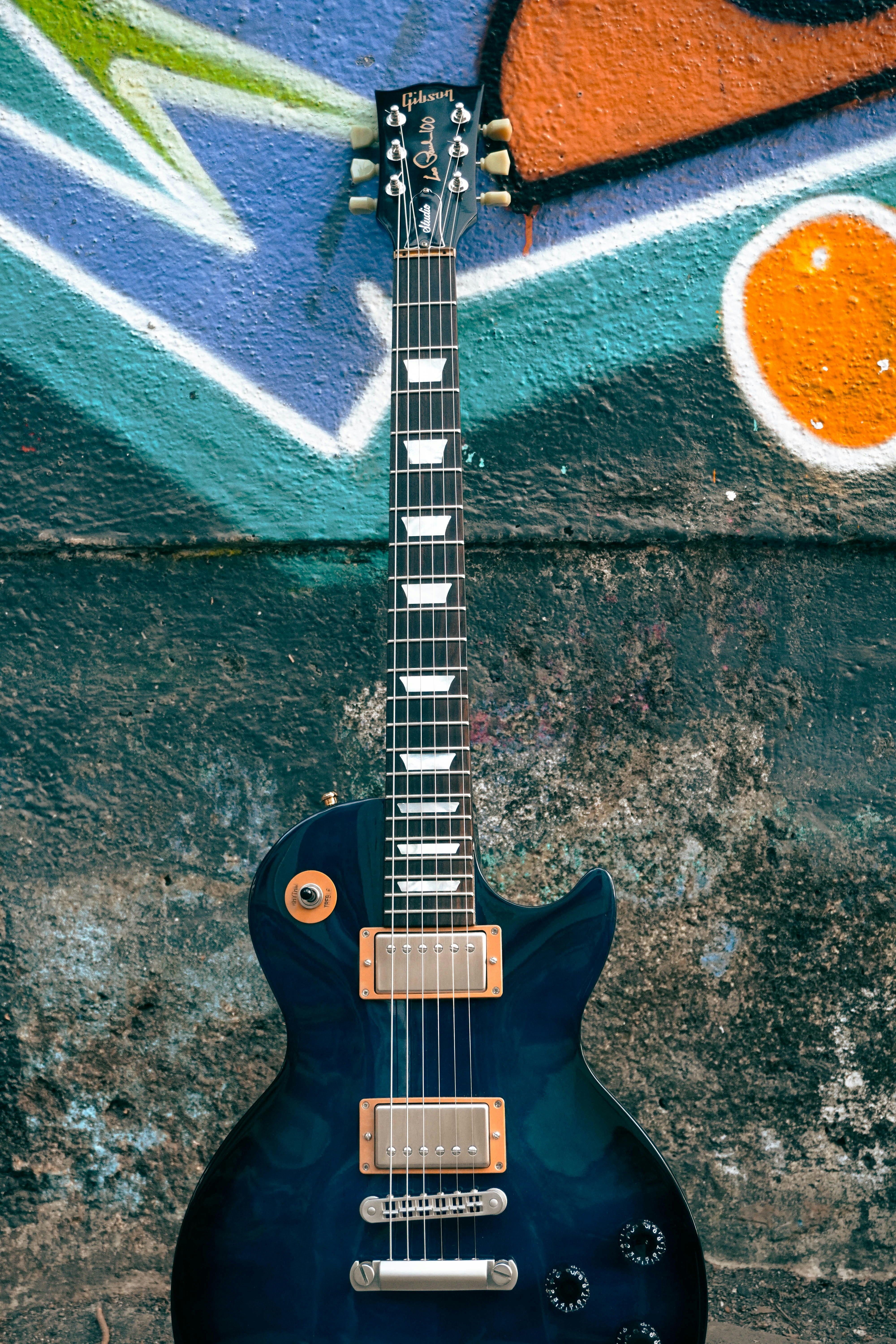 Midnight Sunburst: An Electric Gibson Quietly Standing Against Street Art