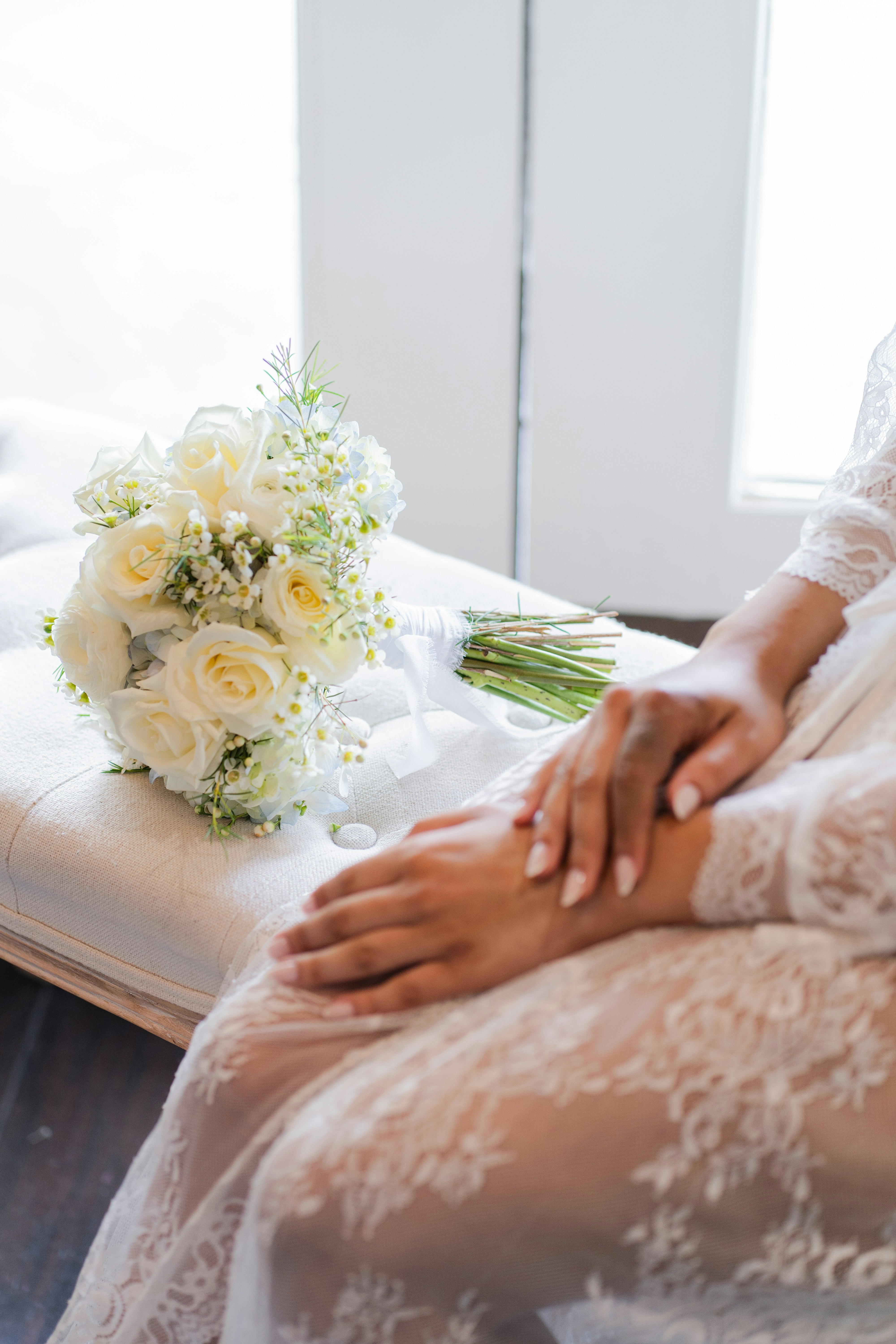 Bride's bouquet and lace-draped hands at a quiet wedding moment