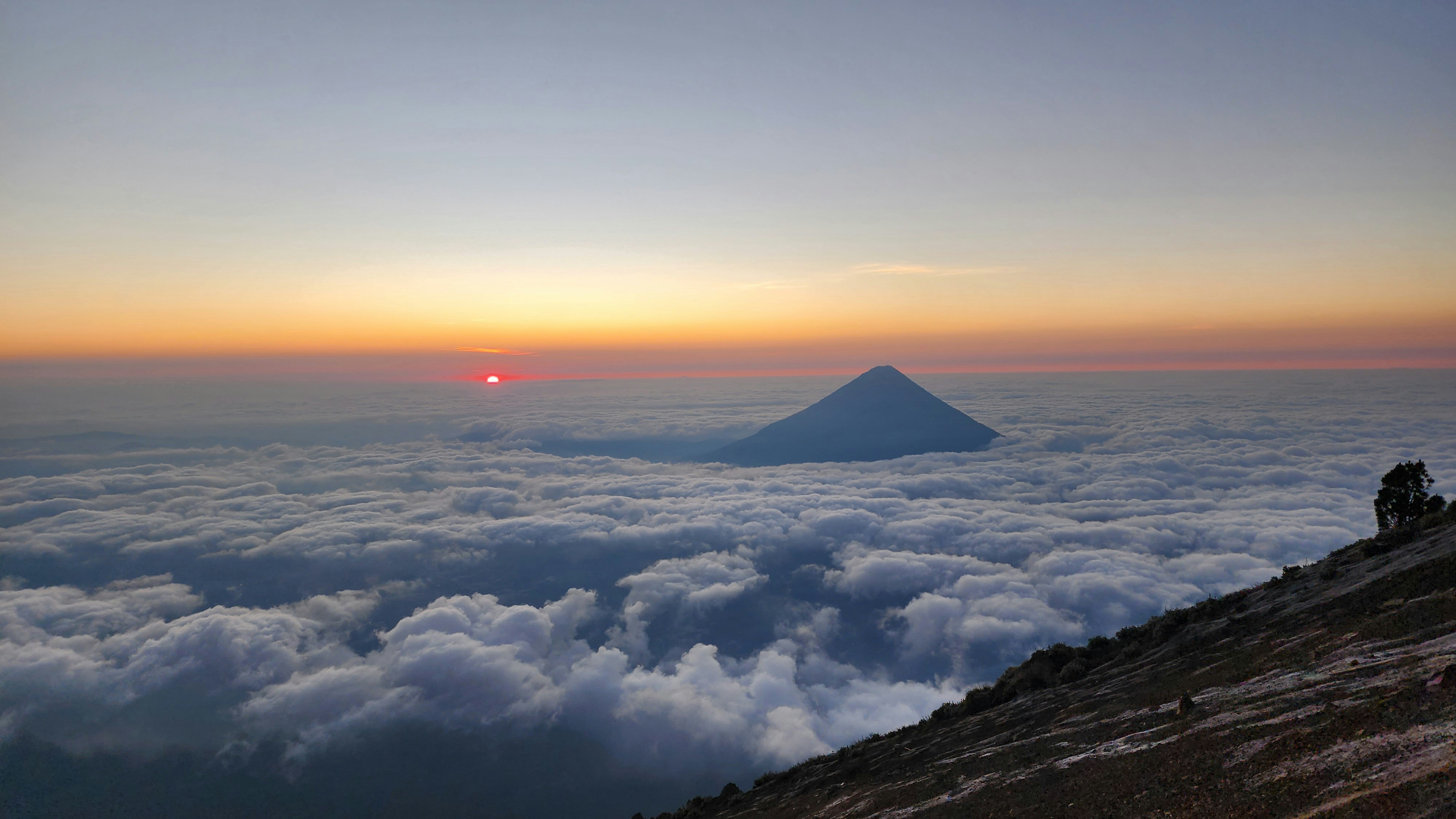 Sunset Over a Lonely Peak Above a Sea of Clouds