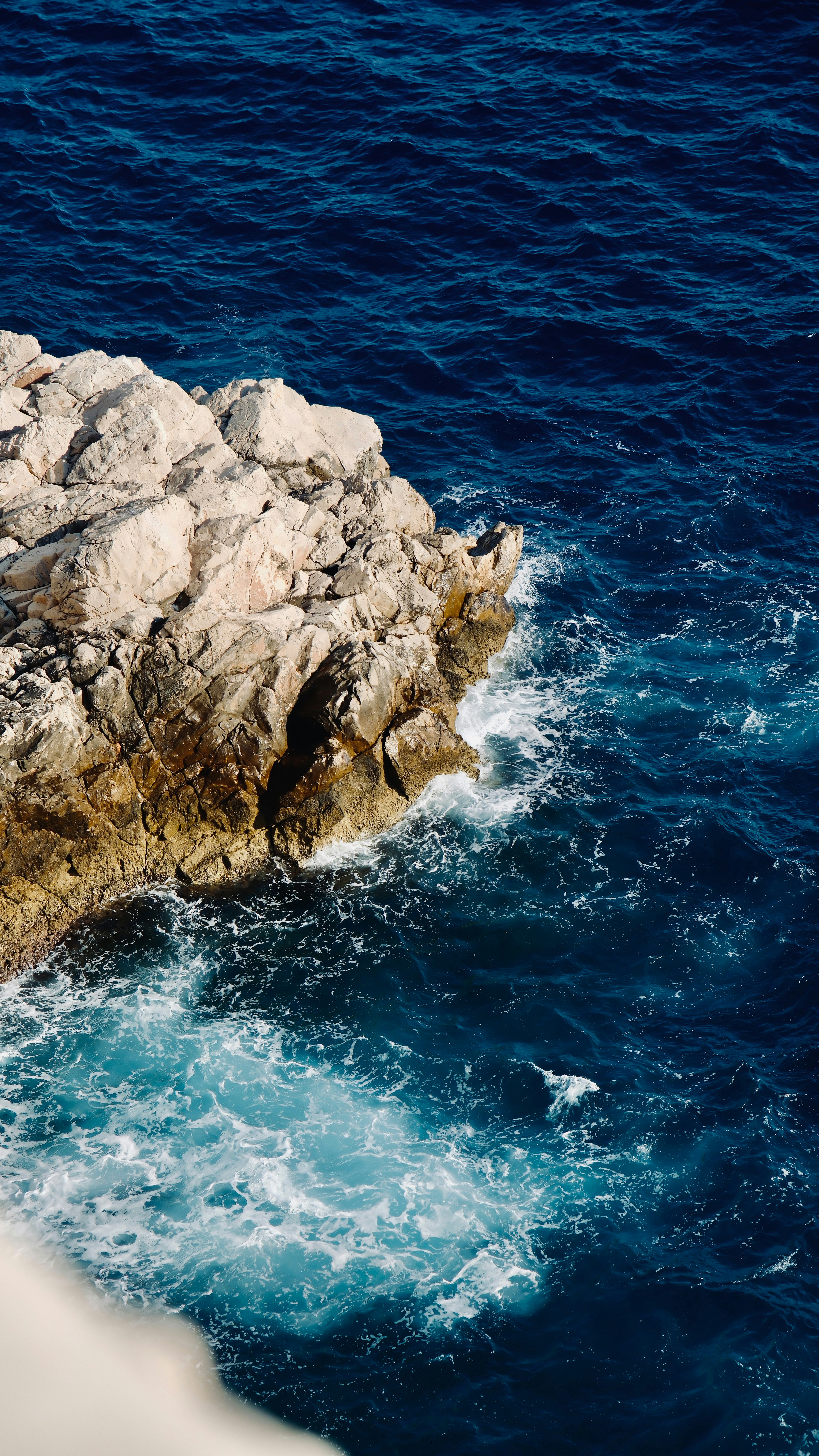 Cliff Edge Over Ocean: Charcoal Rocks Meet Deep Blue Waves