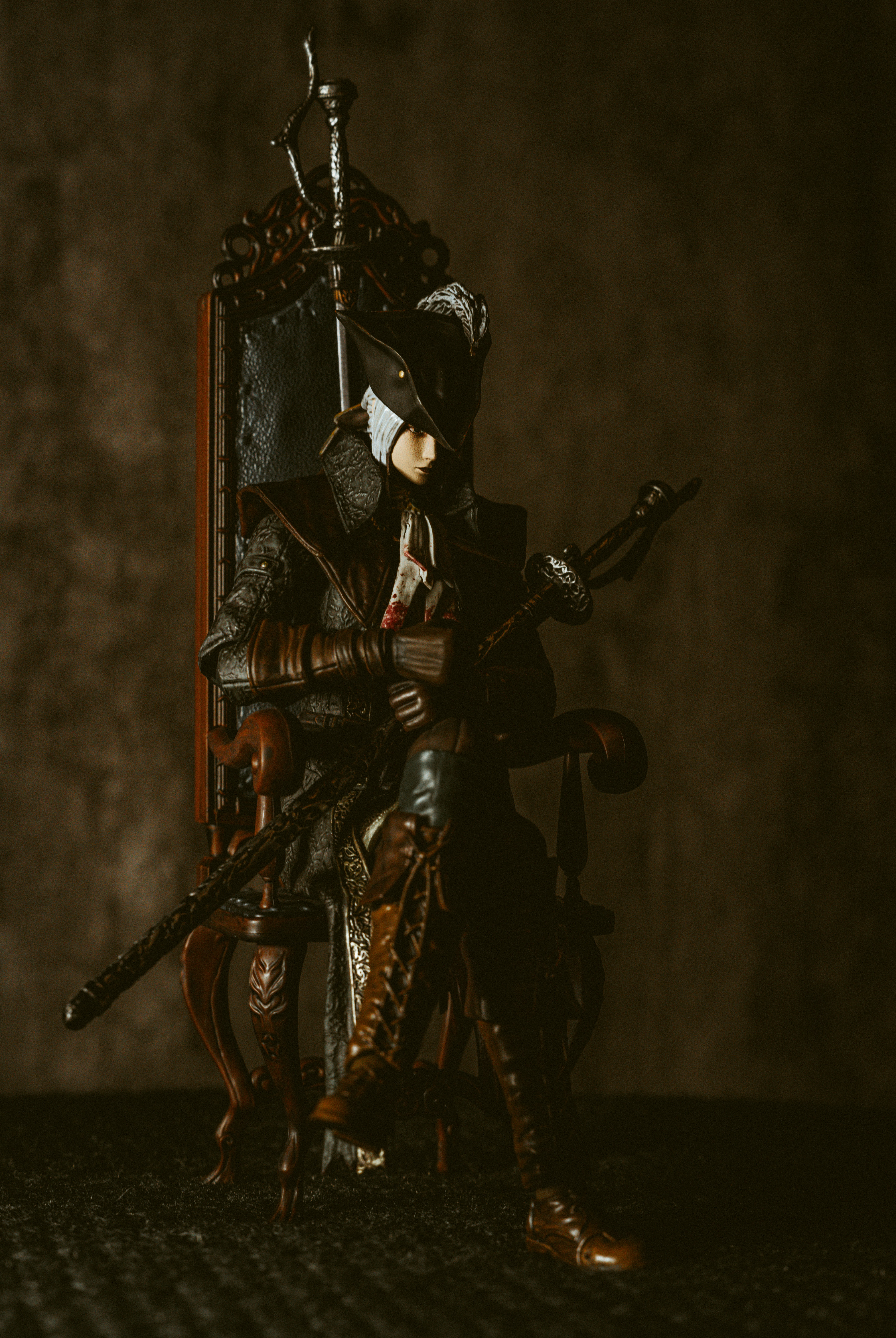 Cloaked Archer on an Ornate Throne: A Dark Figurine in Focus