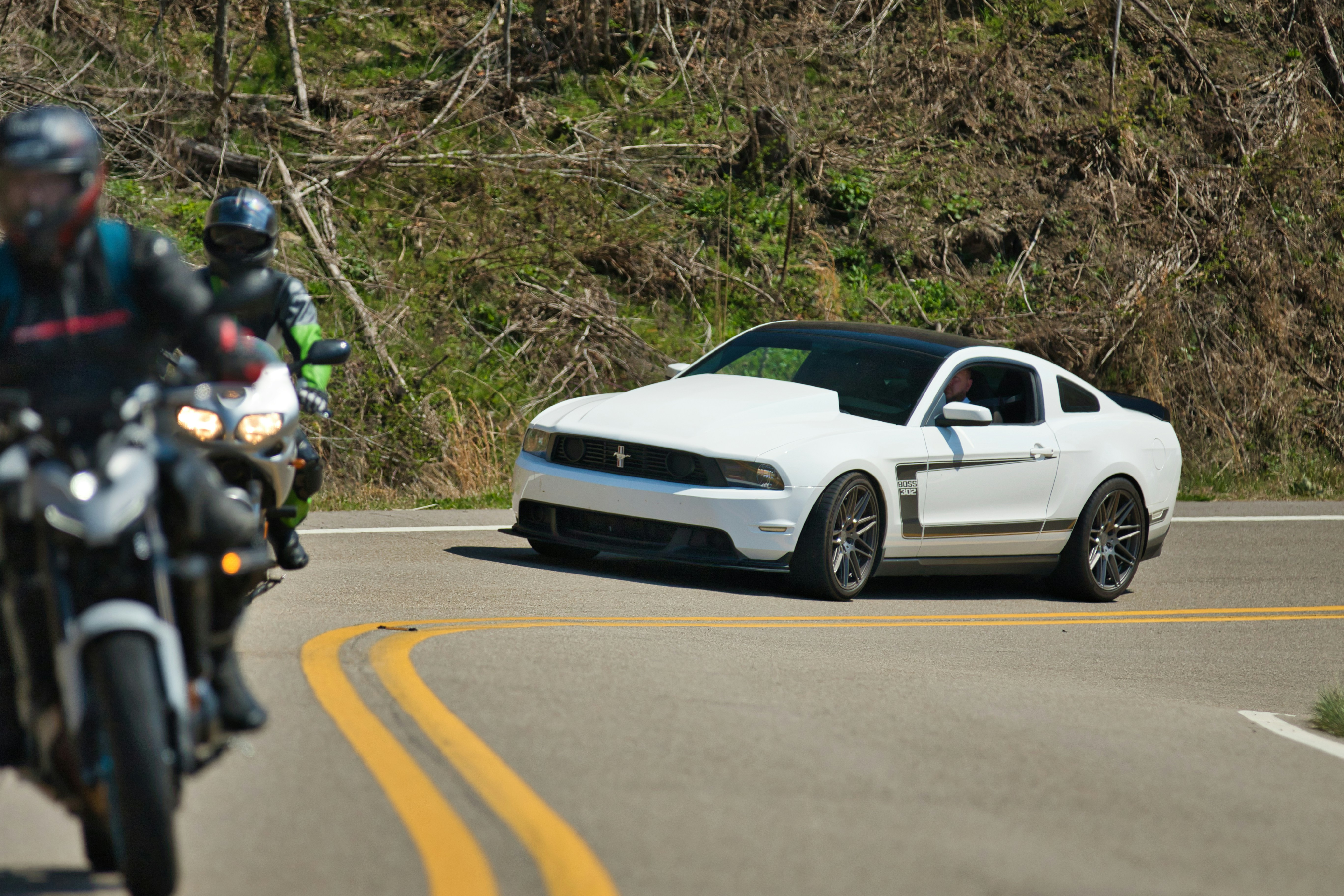 White Ford Mustang Emerges on a Curved Mountain Road