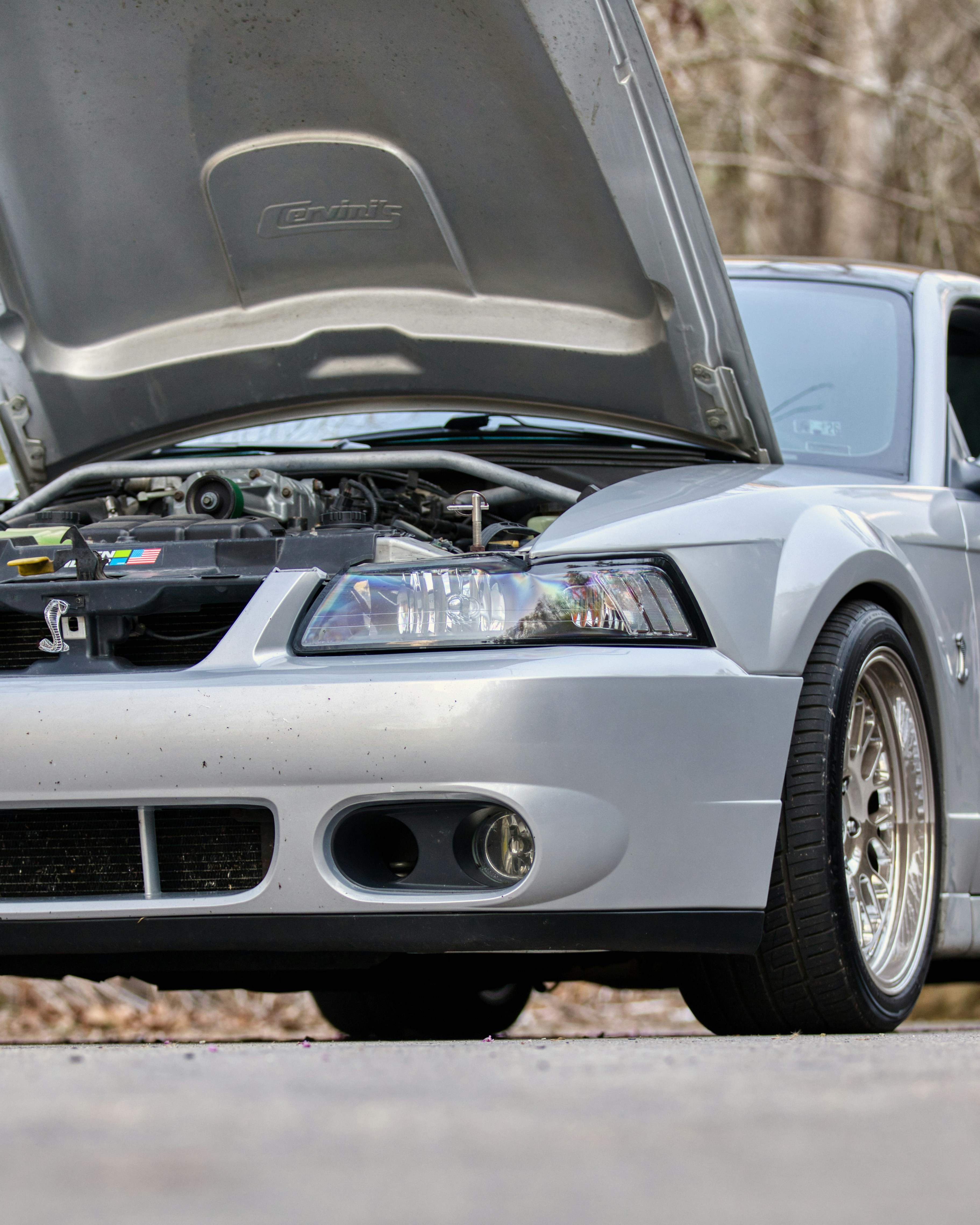 Under the Hood: A Silver Muscle Car with Open Bonnet
