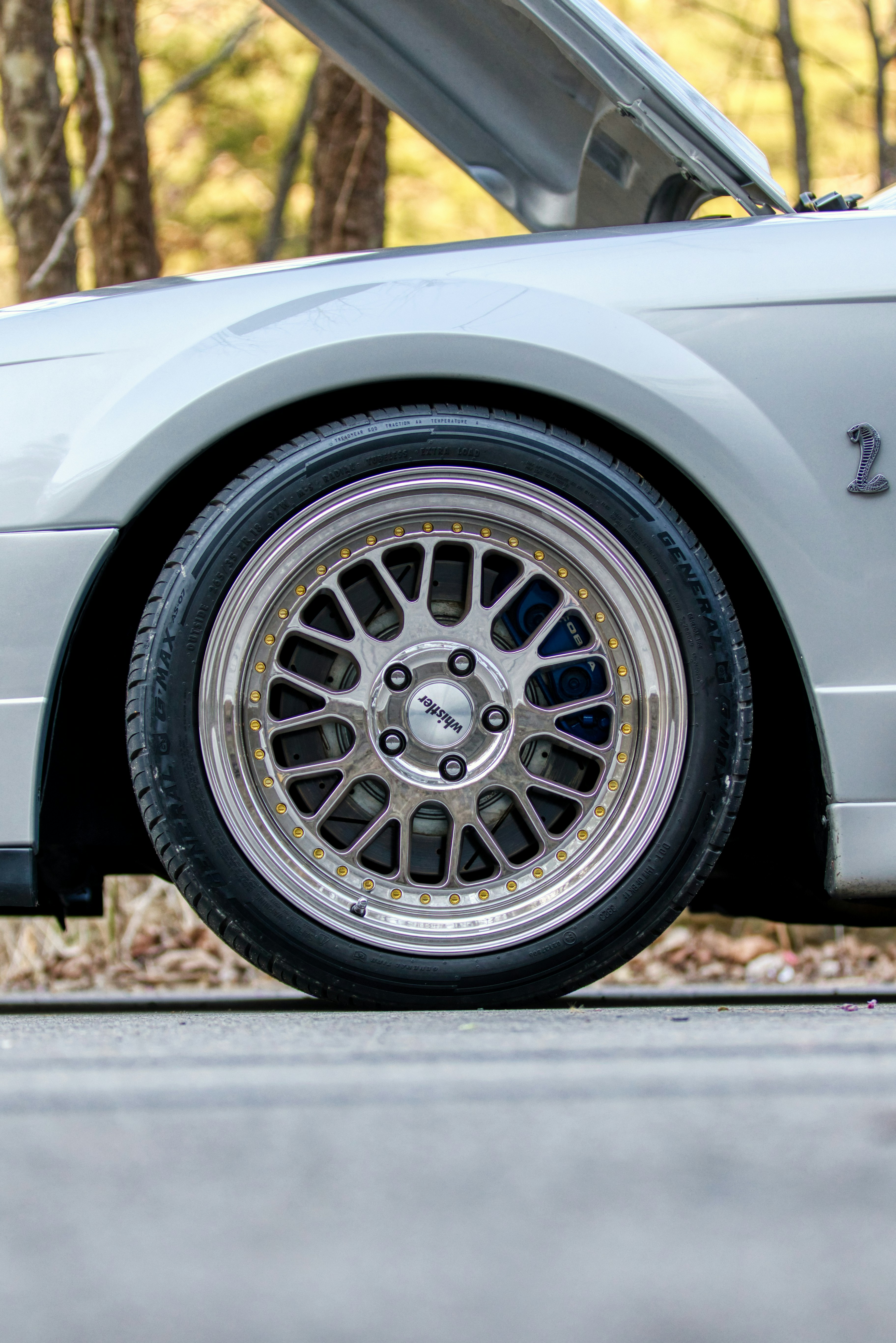 Close-up of a polished alloy wheel and tire on a classic gray sports car