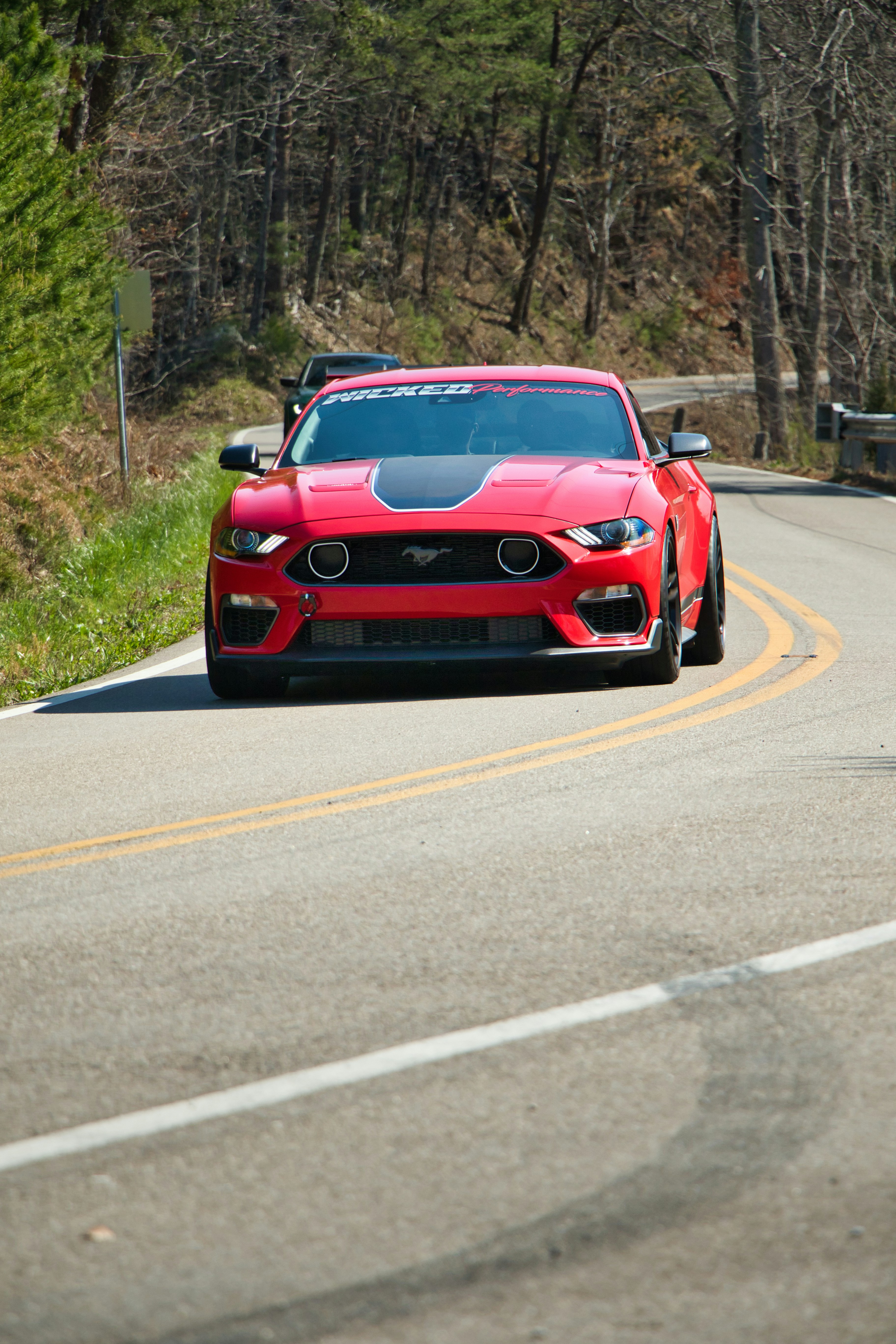 Red Mustang Surges Around a Quiet Mountain Bend