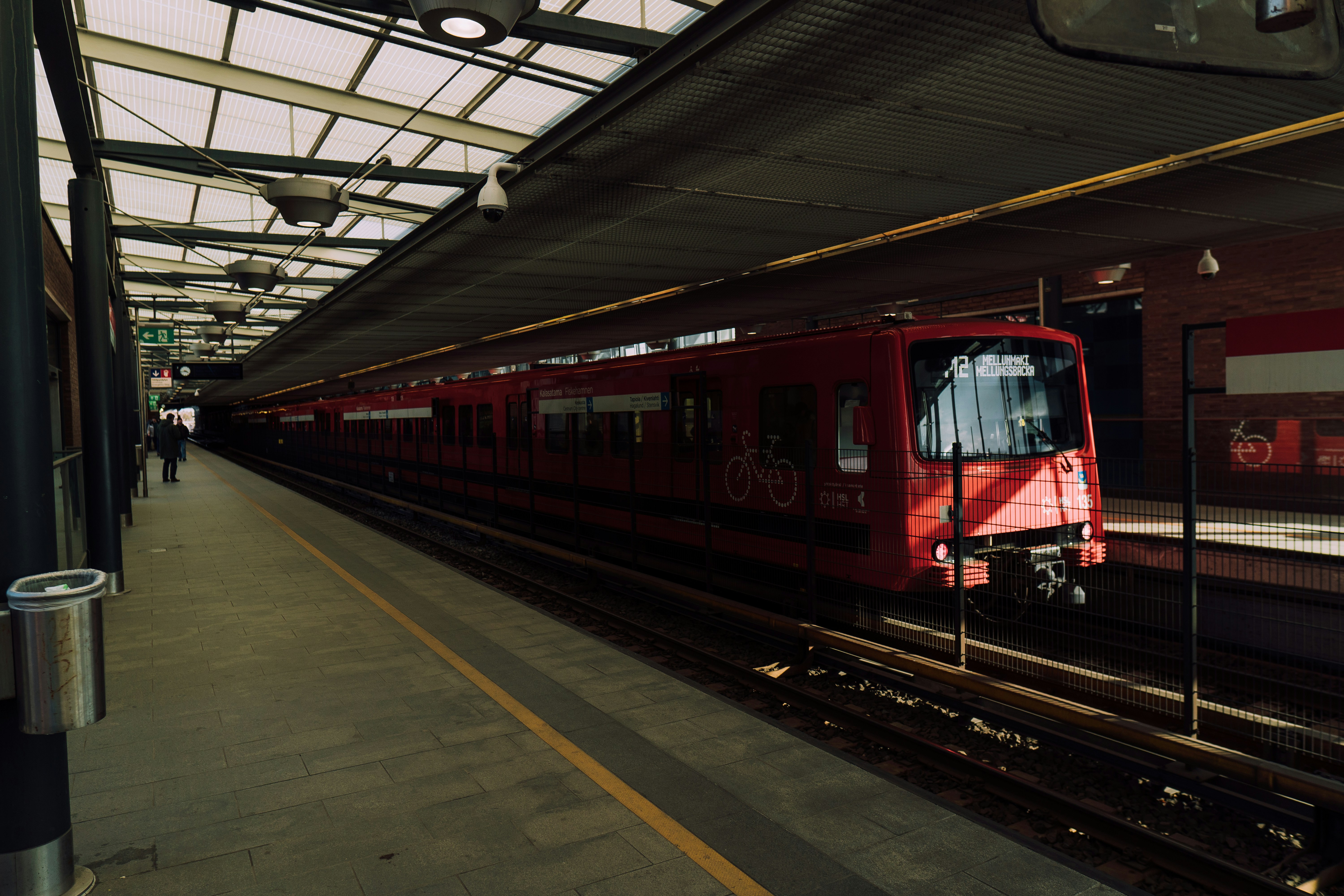 Red Commuter at the Overhead Light—A Quiet Moment on the Platform
