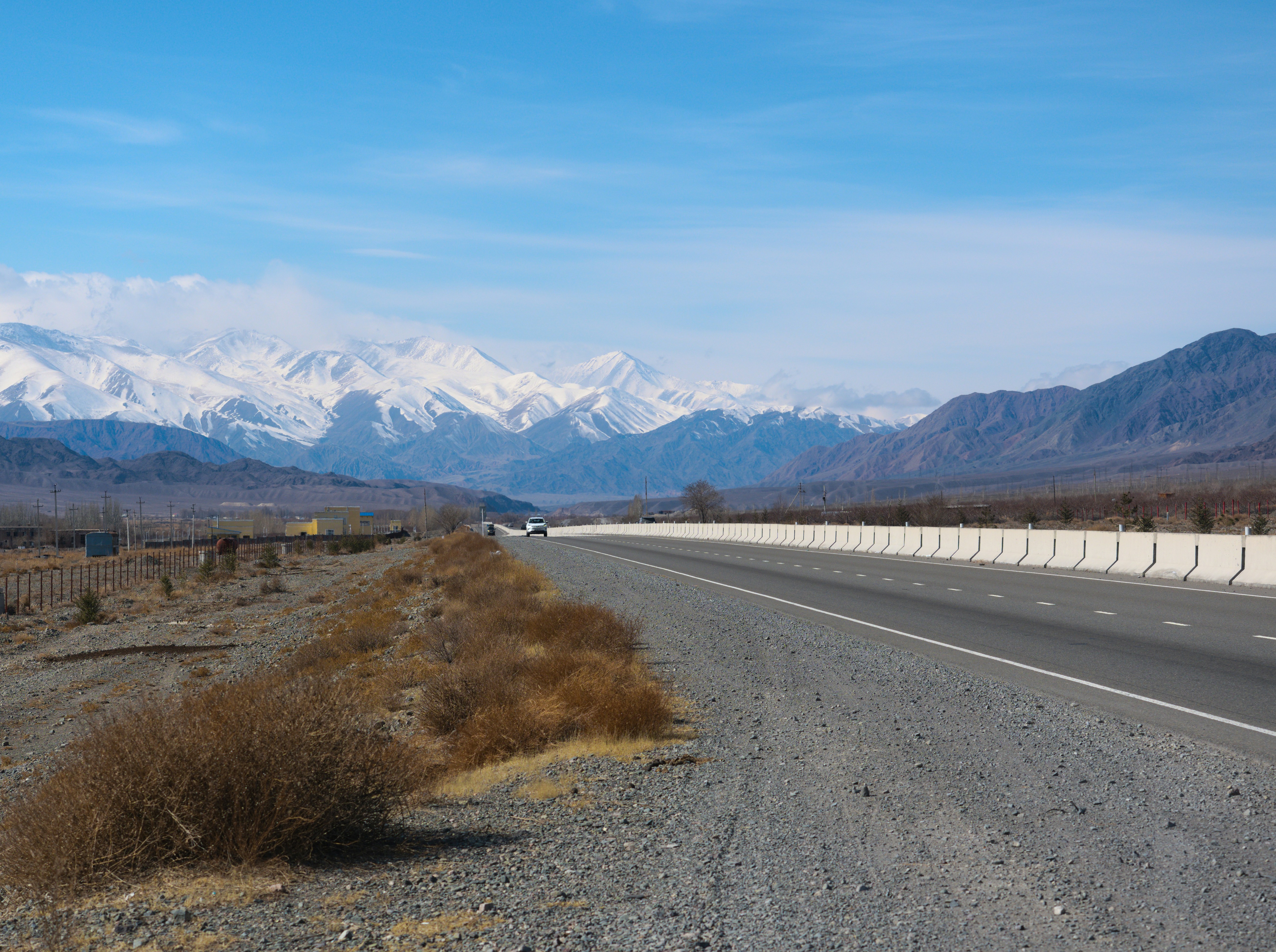 Desert Highway Toward Snow-Capped Peaks