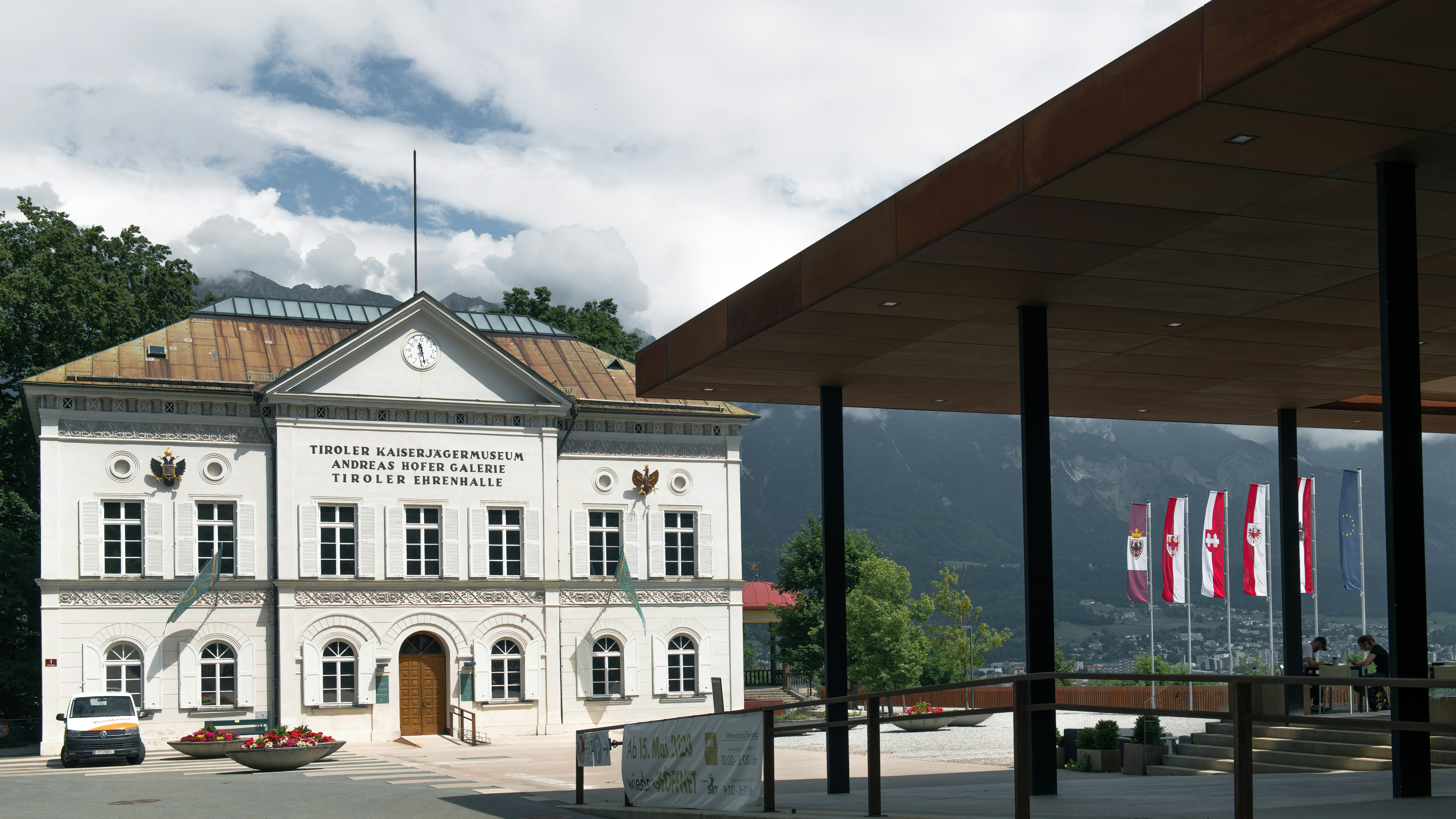Heritage Hall on a Promenade: A Neoclassical Facade with Alpine Backdrop