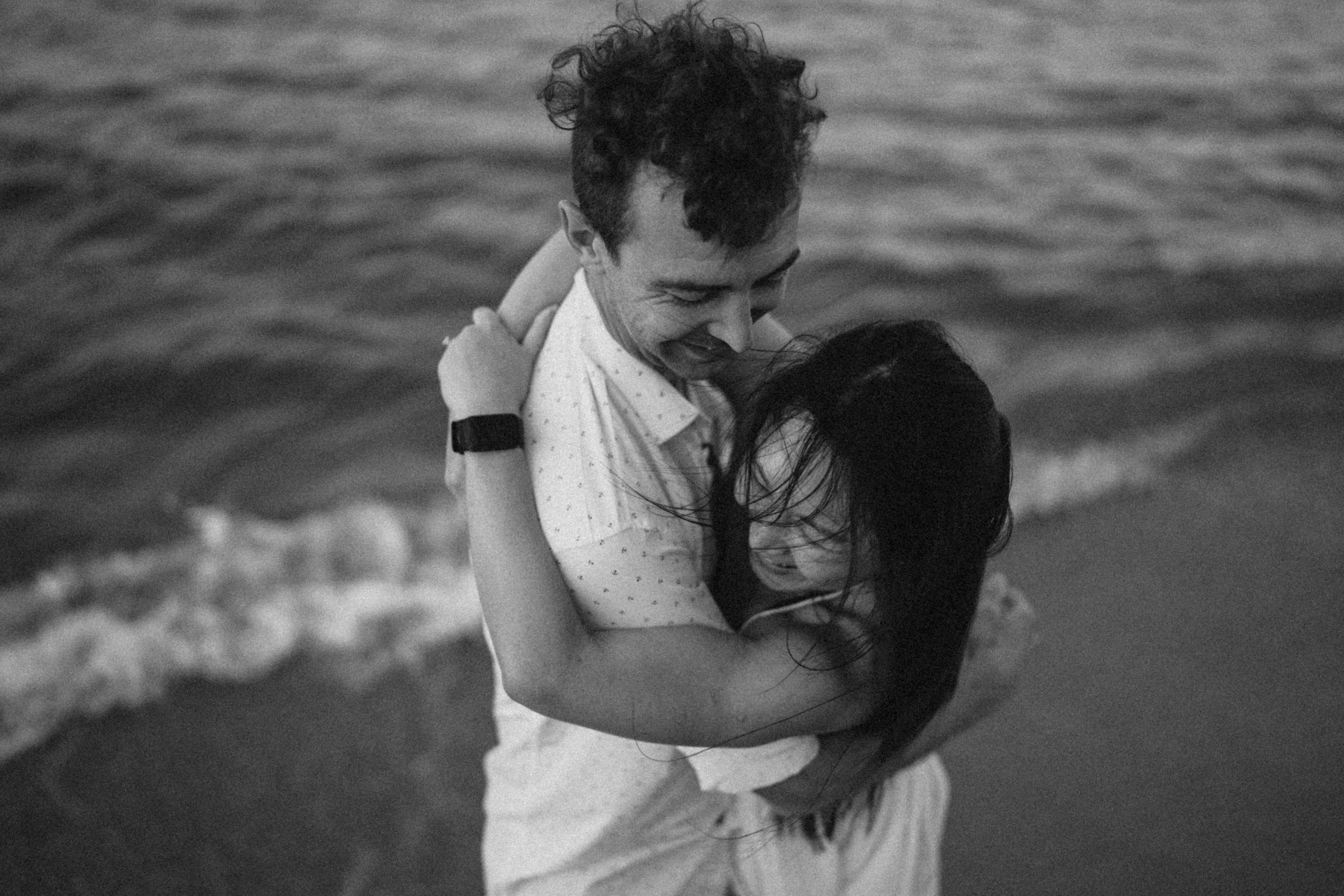 Embrace at the Shore: A Quiet Dance in Black and White