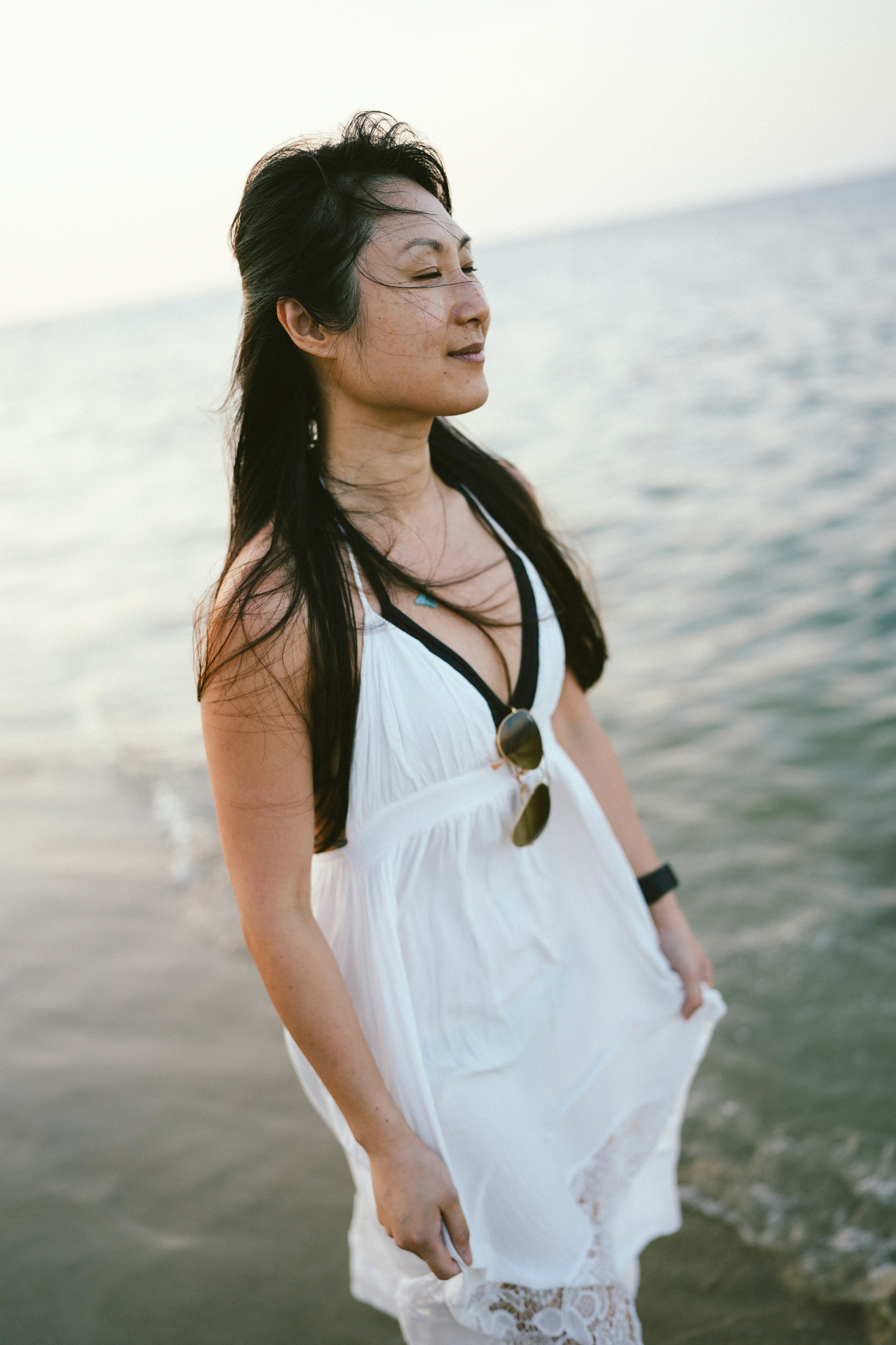 Sea breeze and white dress: a seaside portrait in soft evening light